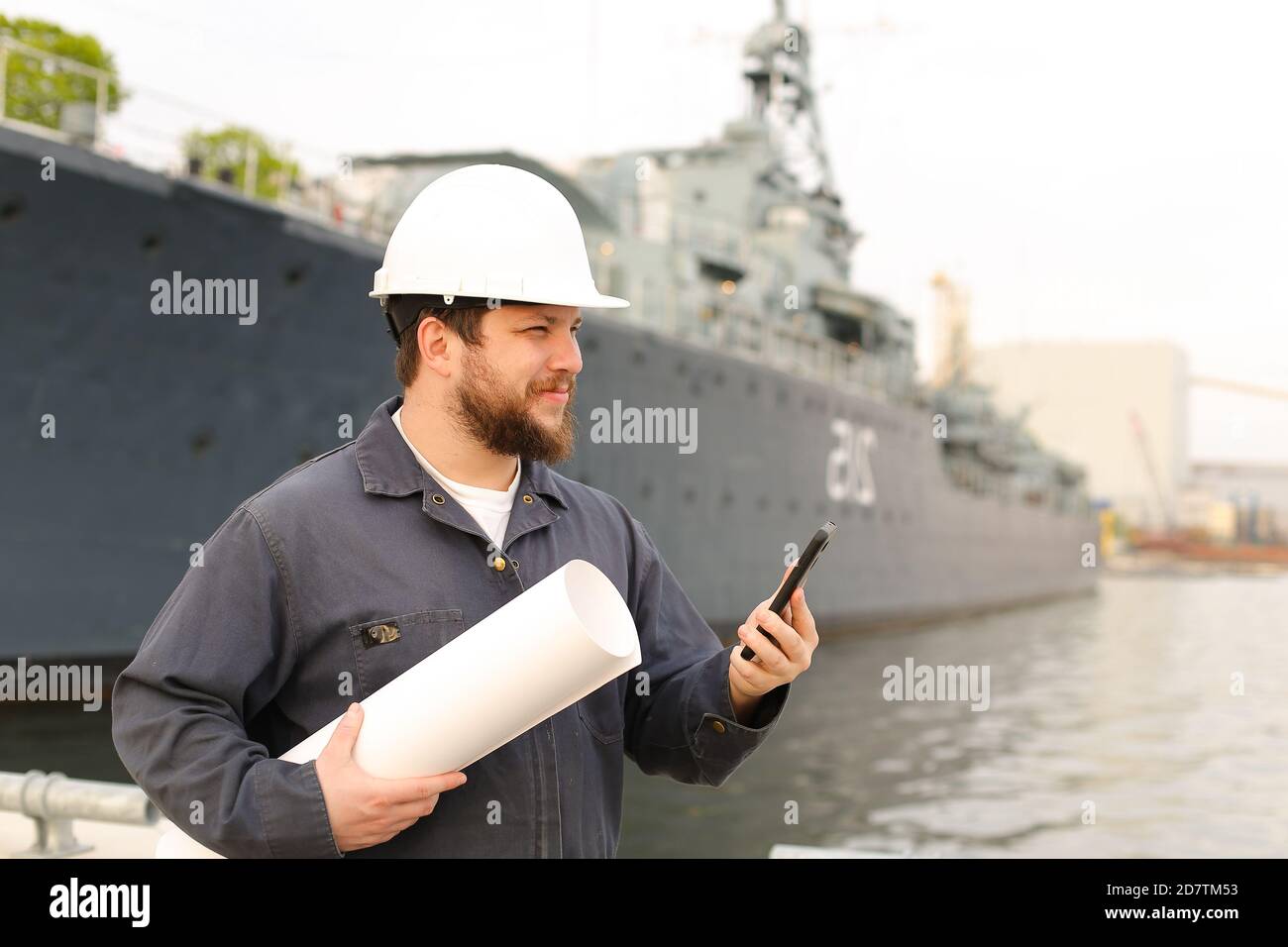 Marine engineer talking by VHF walkie talkie, holding papers near ...