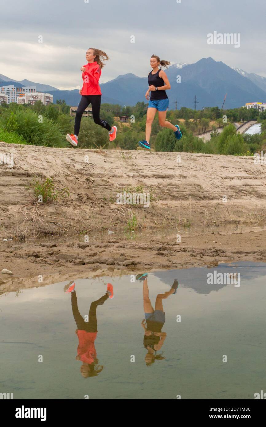 Two beautiful girls came to the city park in new sportswear to go ...