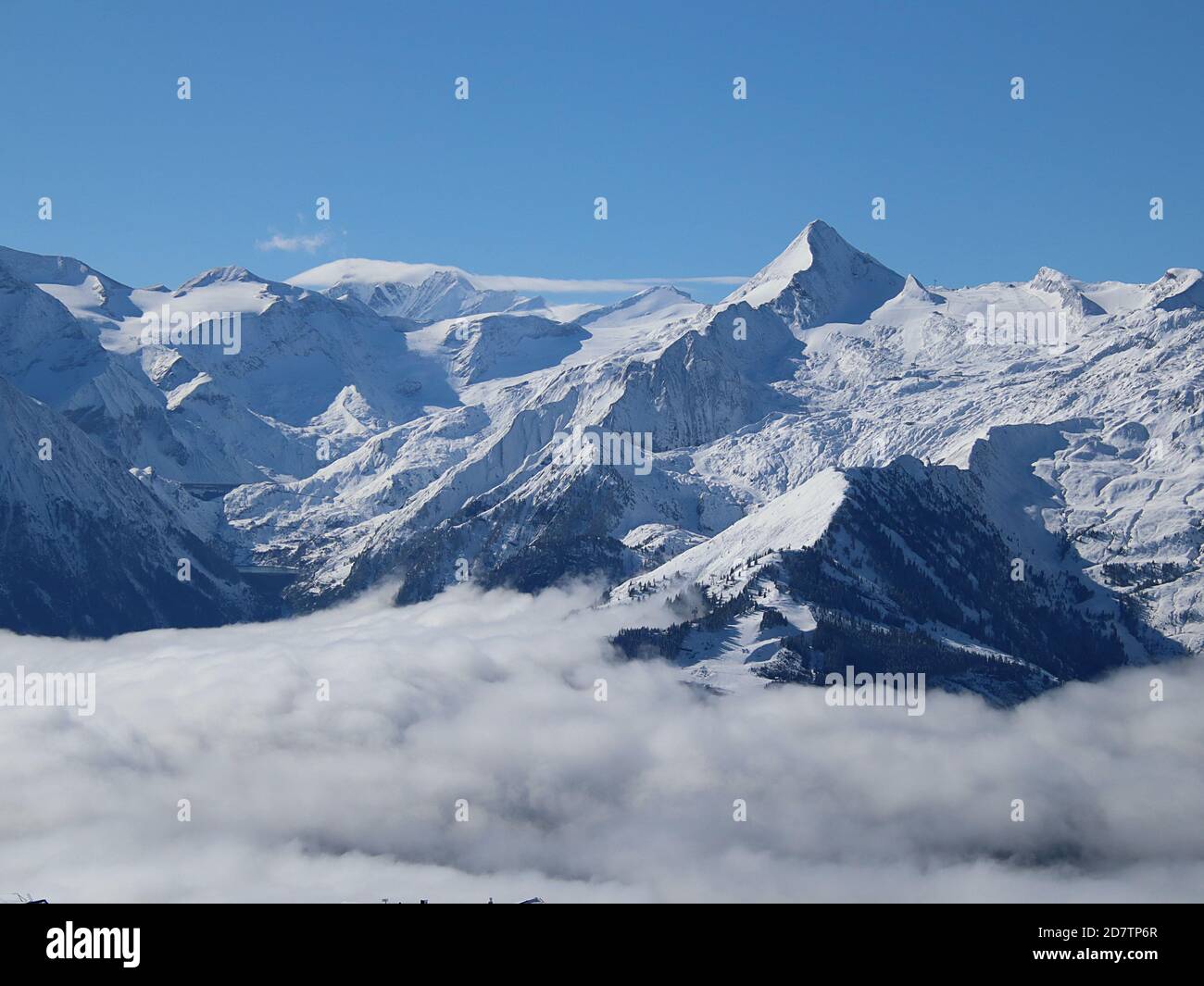 Snowy mountains rise above the mist Stock Photo - Alamy
