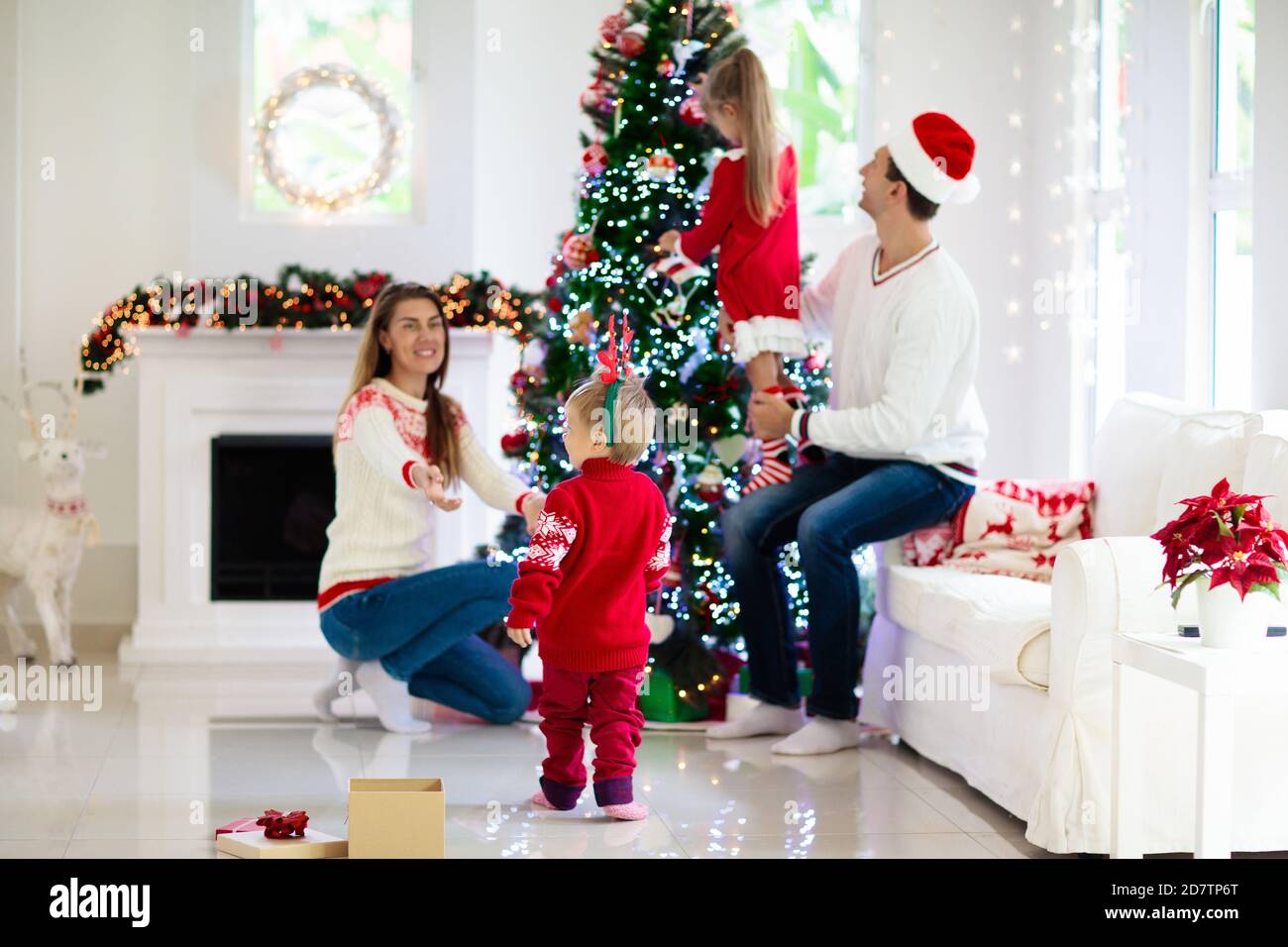Family celebrating Christmas. Parents and kids decorate Xmas tree and ...