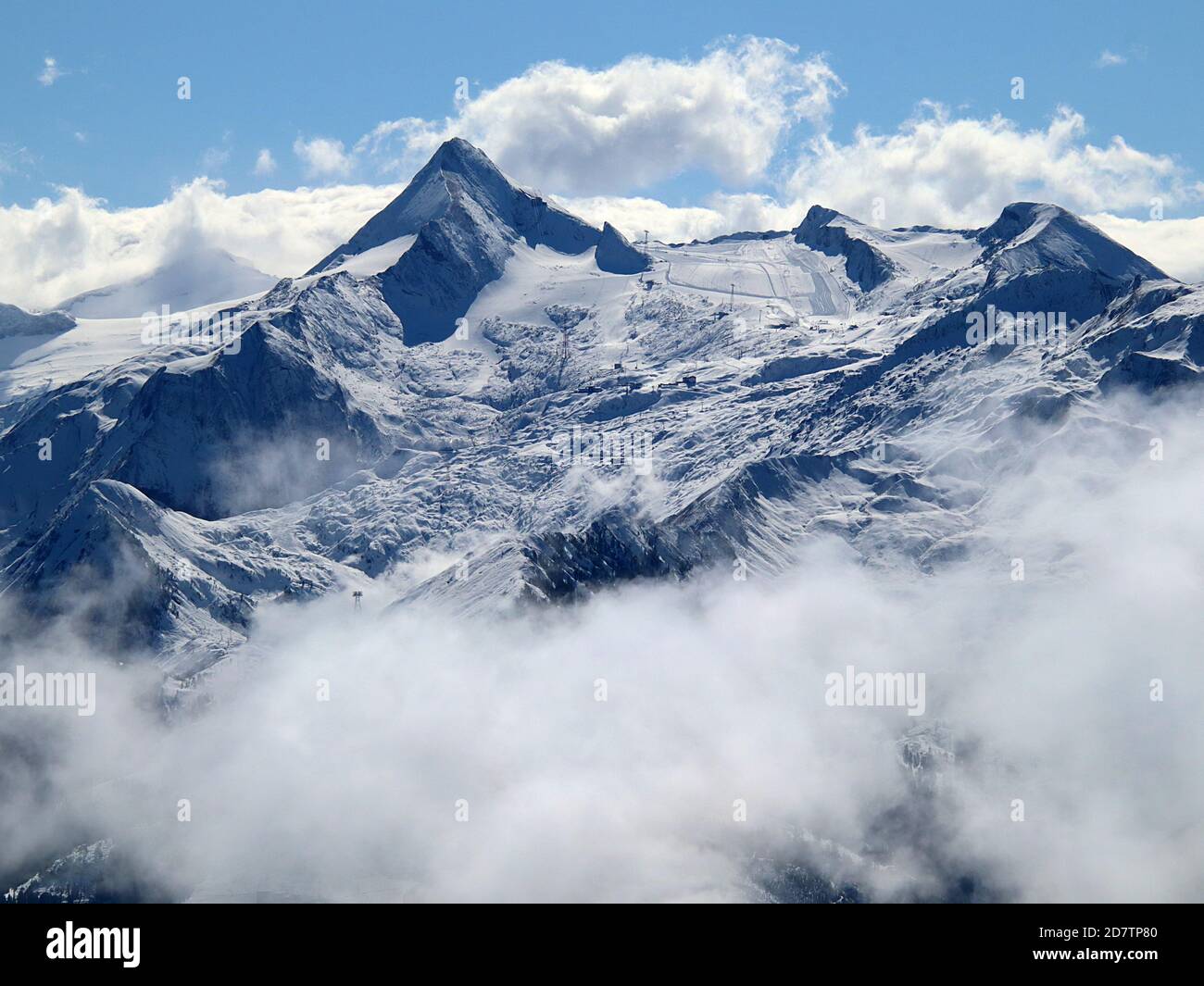 Snowy mountains rise above the mist Stock Photo - Alamy