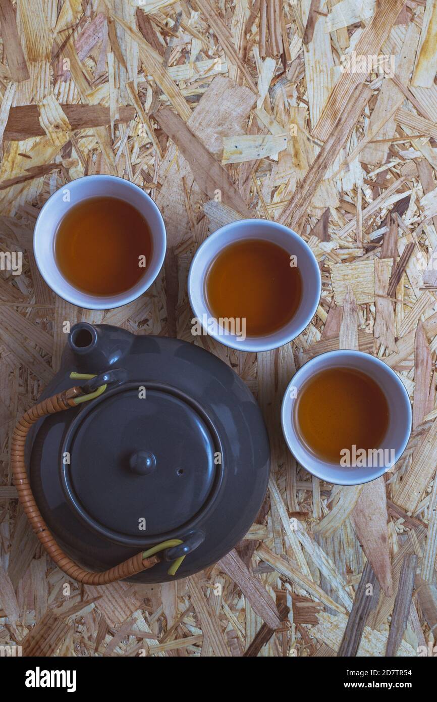 Vertical top view of gray tea set on a pressed wooden panel surface ...