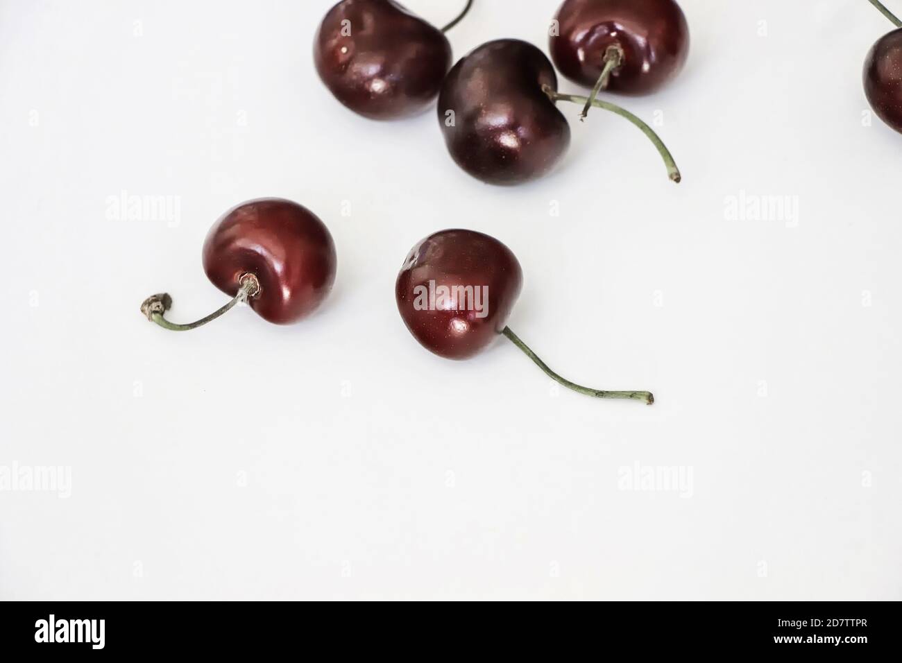 flat lay of red cherry fruits on white background Stock Photo - Alamy