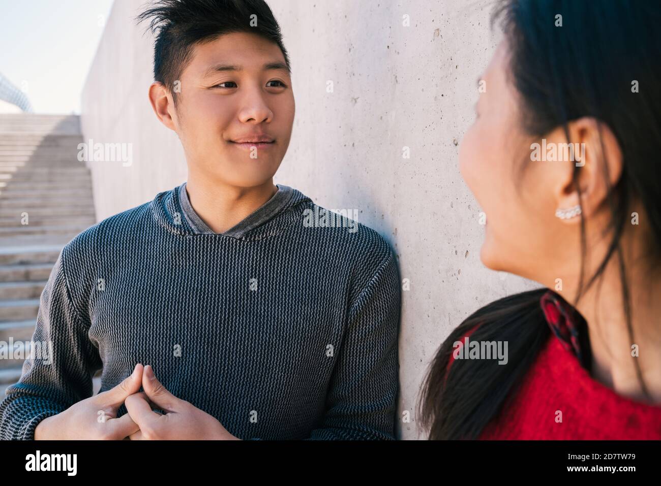 Portrait of lovely Asian couple having a conversation while looking at ...