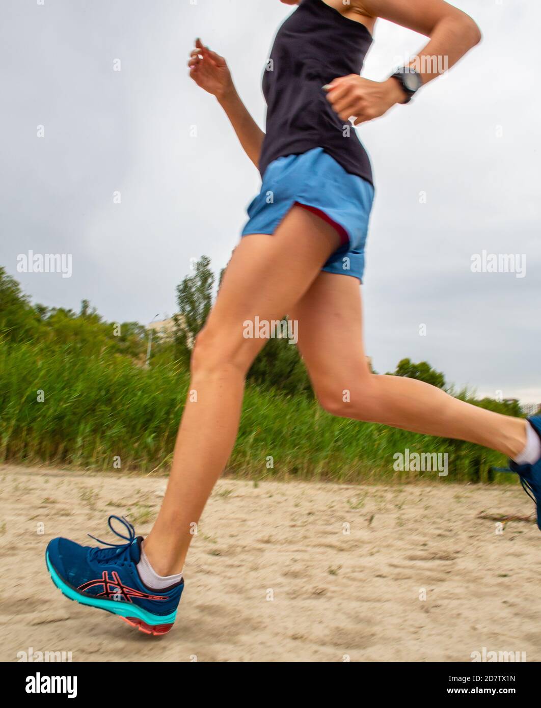 Woman jogging down an outdoor trail at sunset Stock Photo - Alamy