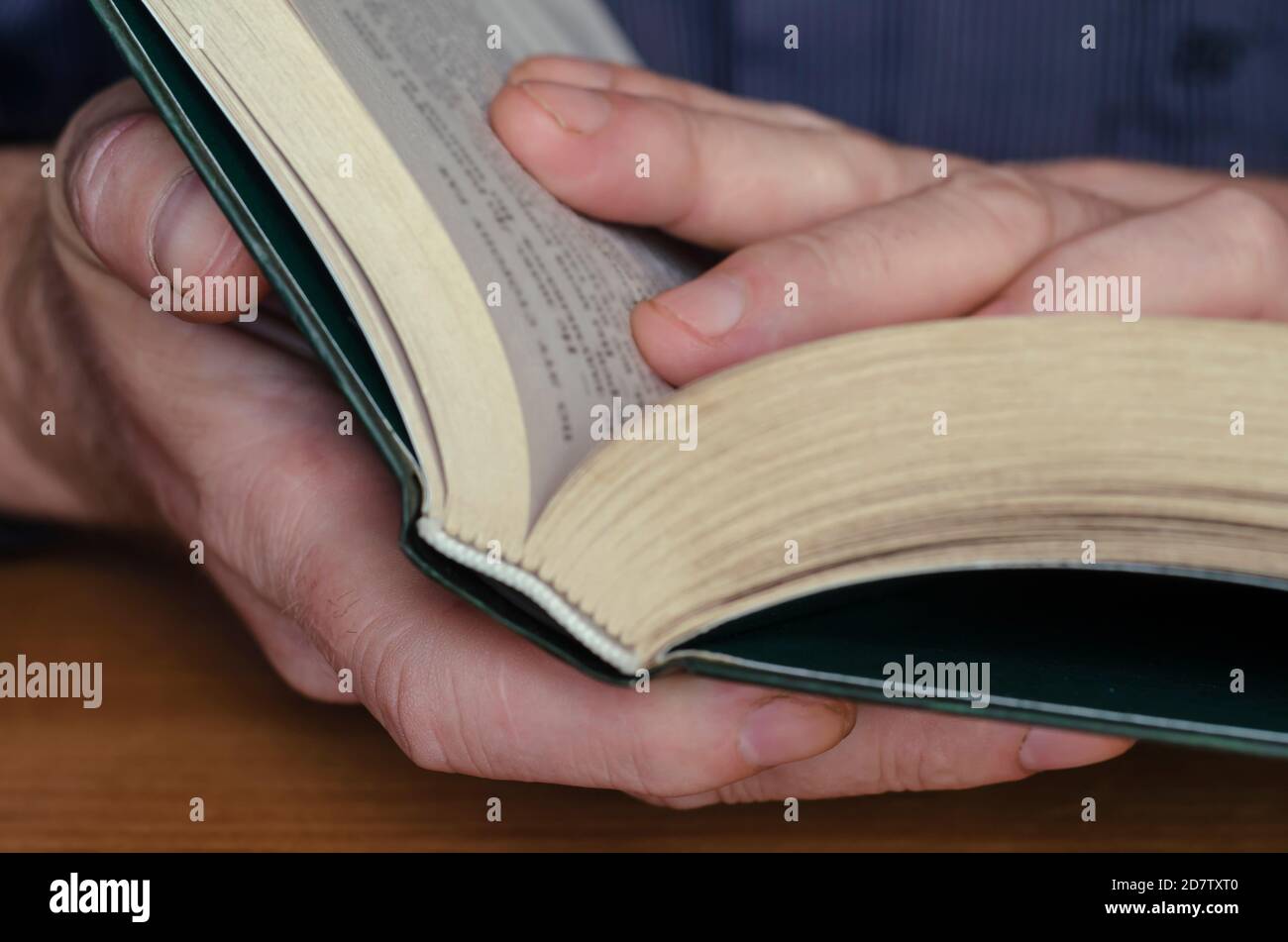 Book is in close-up hands. Thick book in hard pellet in men's hands ...