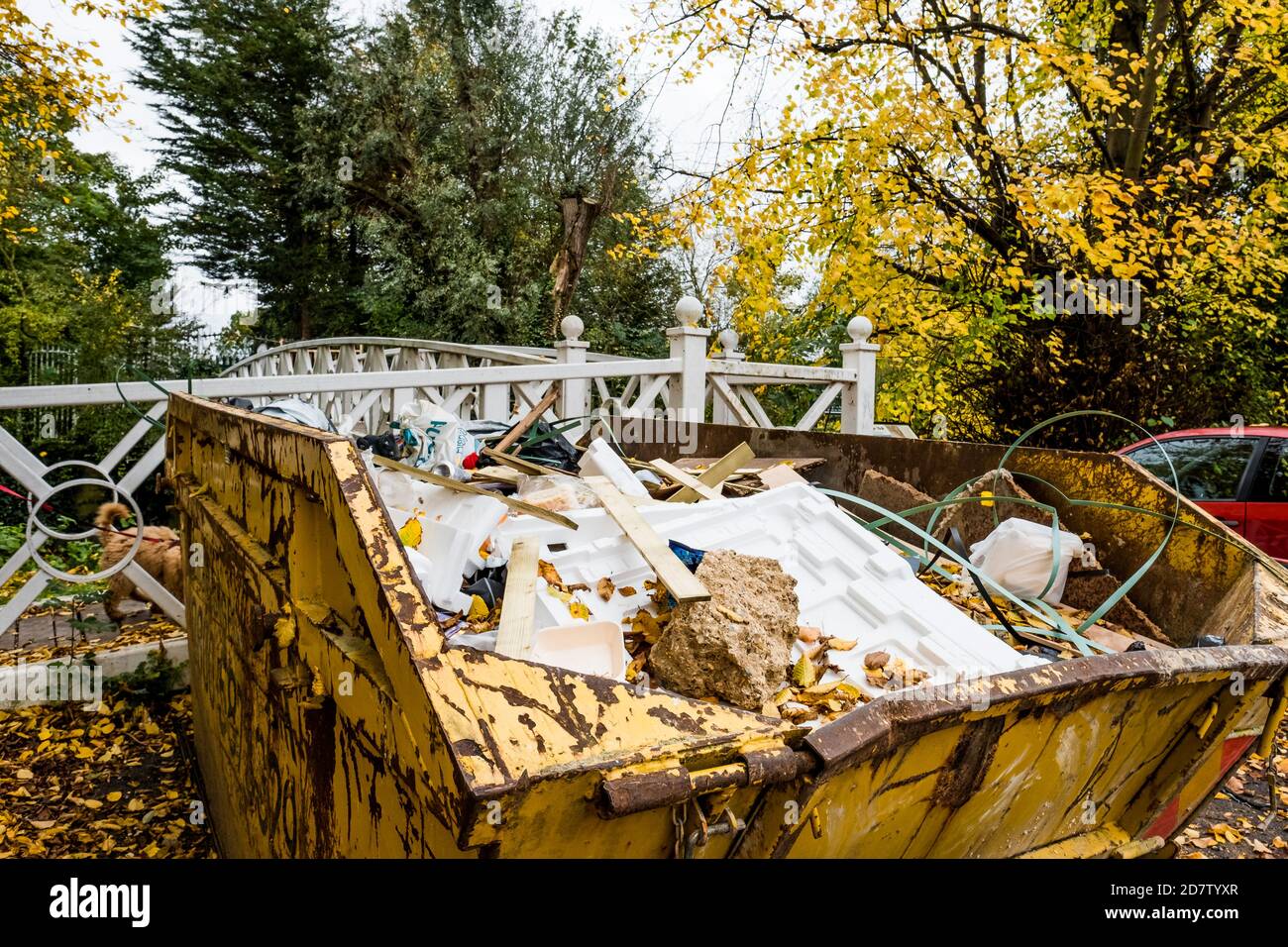Filled yellow rubbish Skip seen located near a bridge leading to a ...