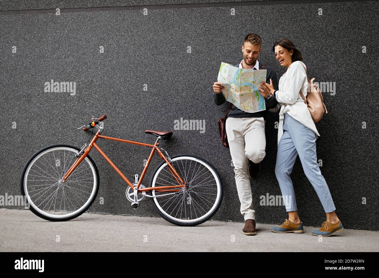 Happy young couple of travellers holding map in hands Stock Photo - Alamy