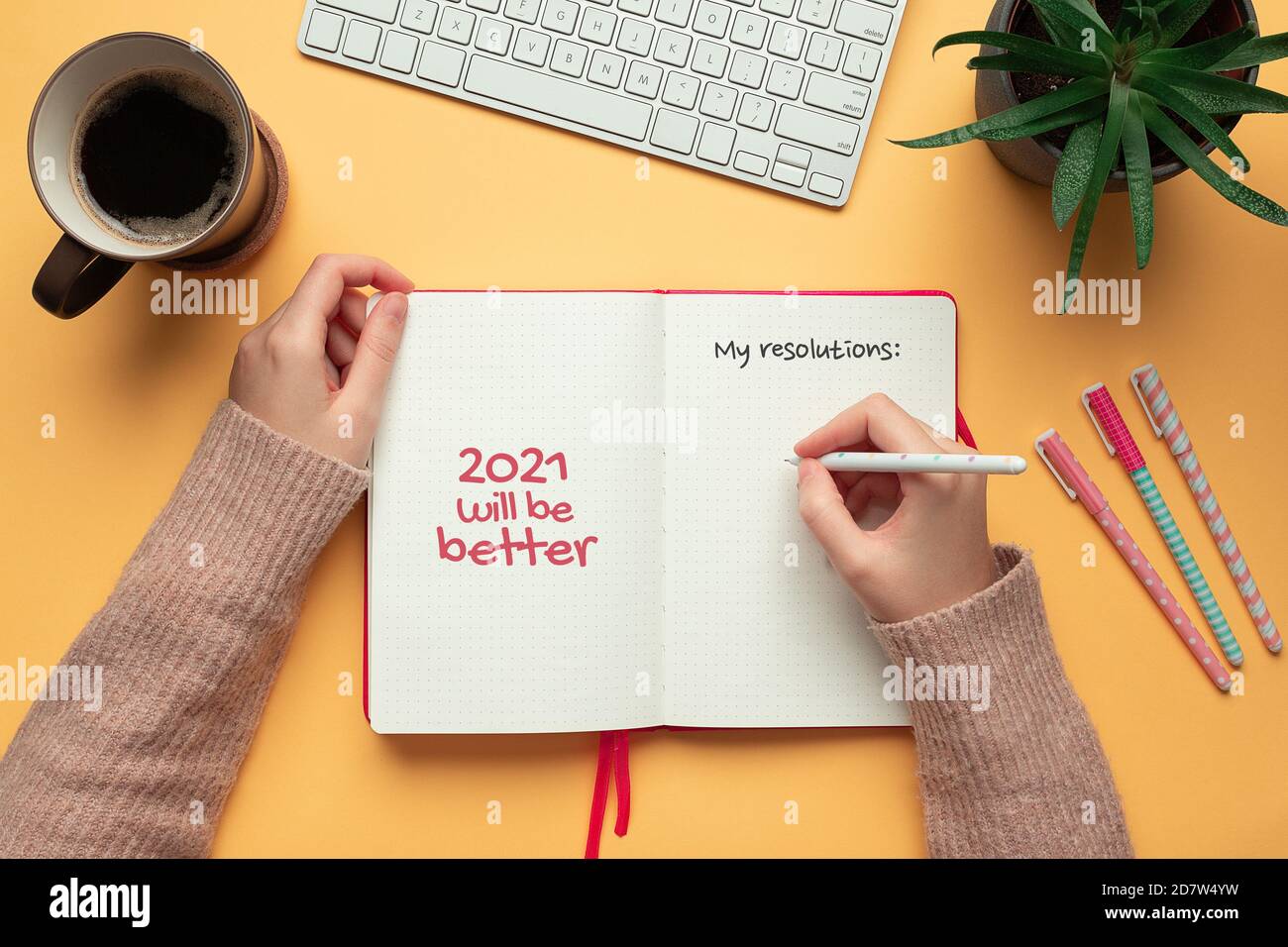 Stock photo of woman writing resolutions in a 2021 new year notebook on ...