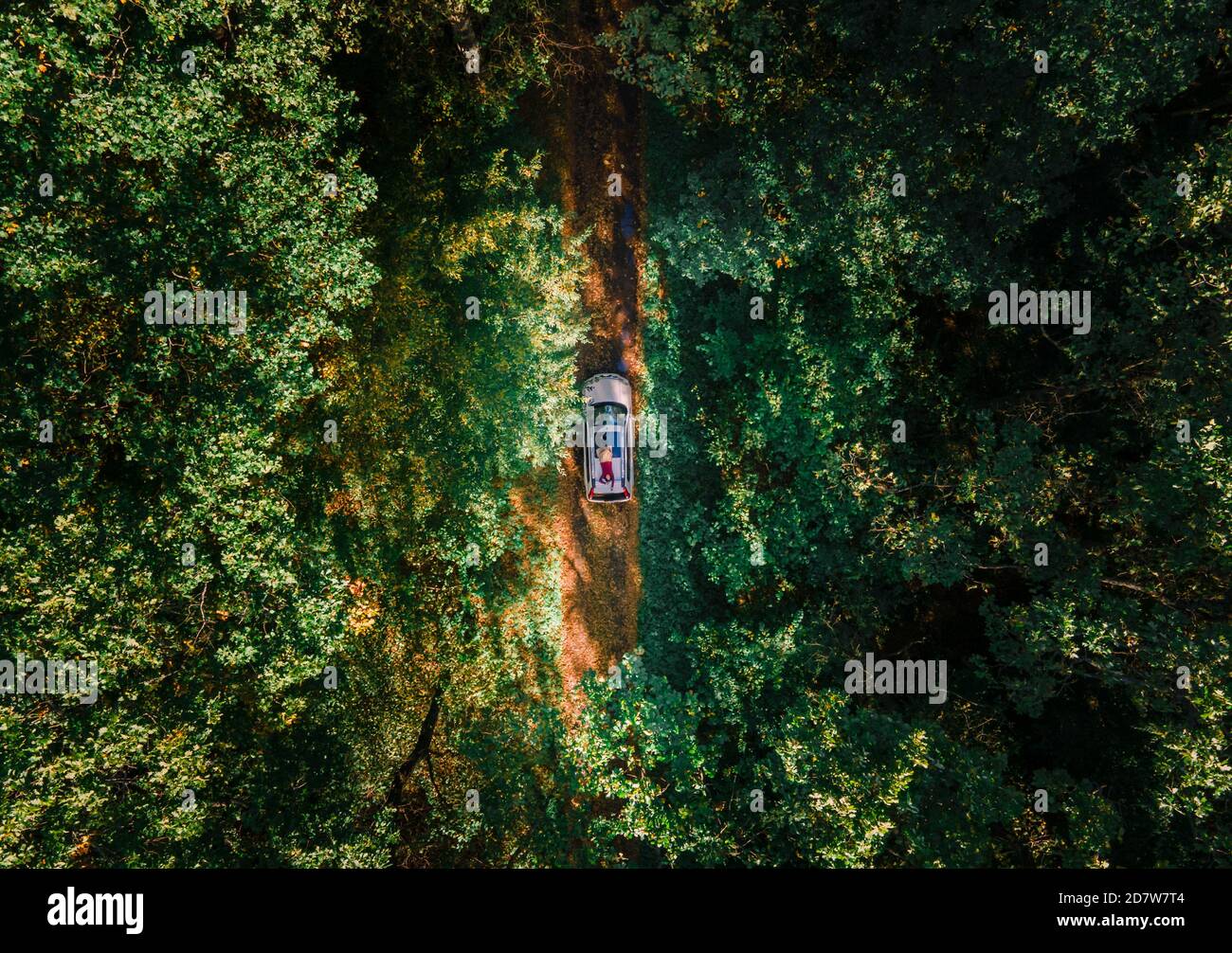 aerial view woman laying down on suv car roof in the middle of the ...