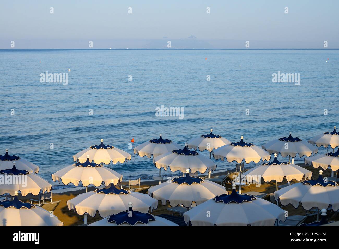 Colorful parasols on sandy beach of medieval small touristic coastal ...