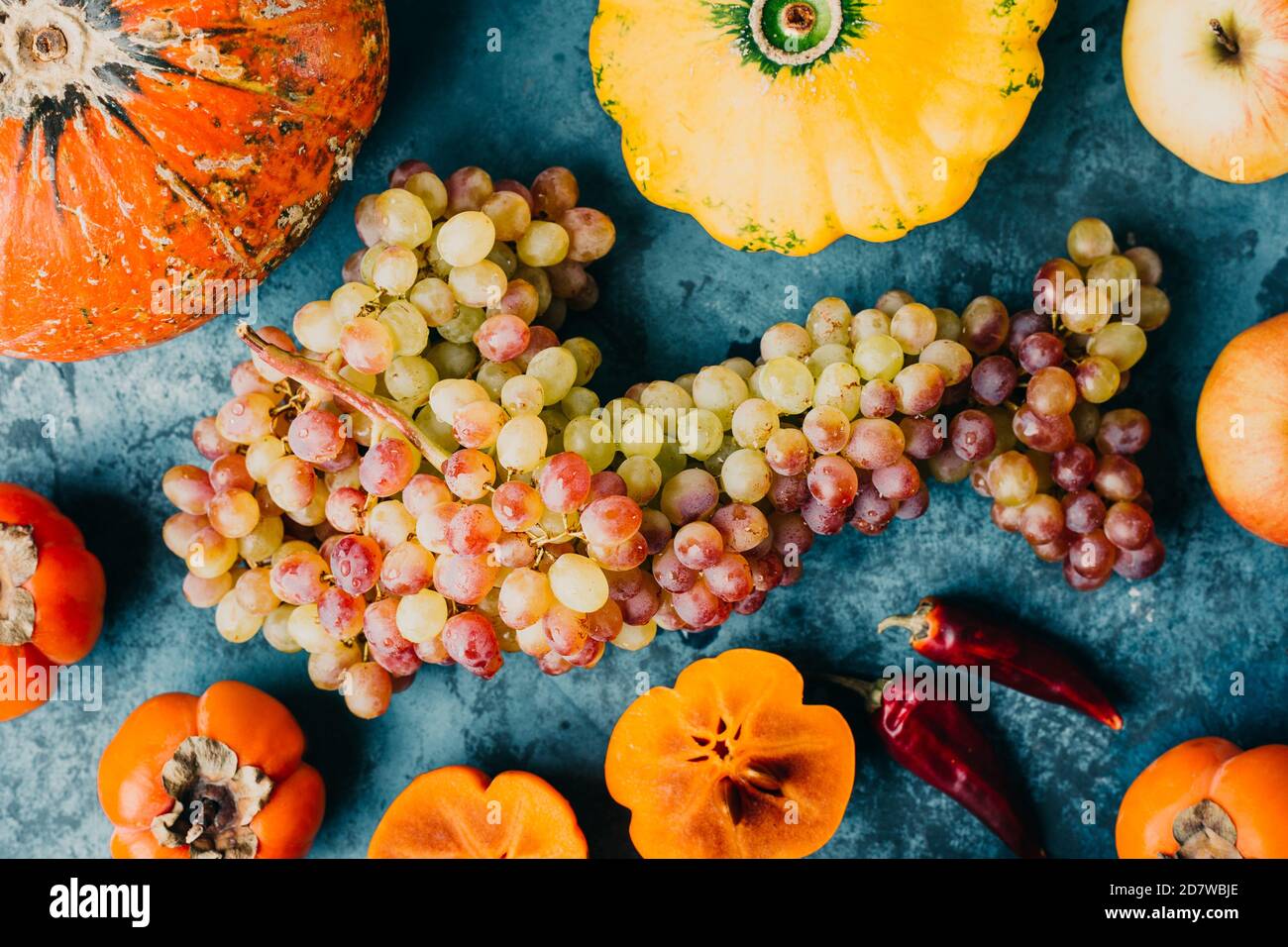 Autumnal fruits and vegetables. A bunch of grapes, pumpkin and ...