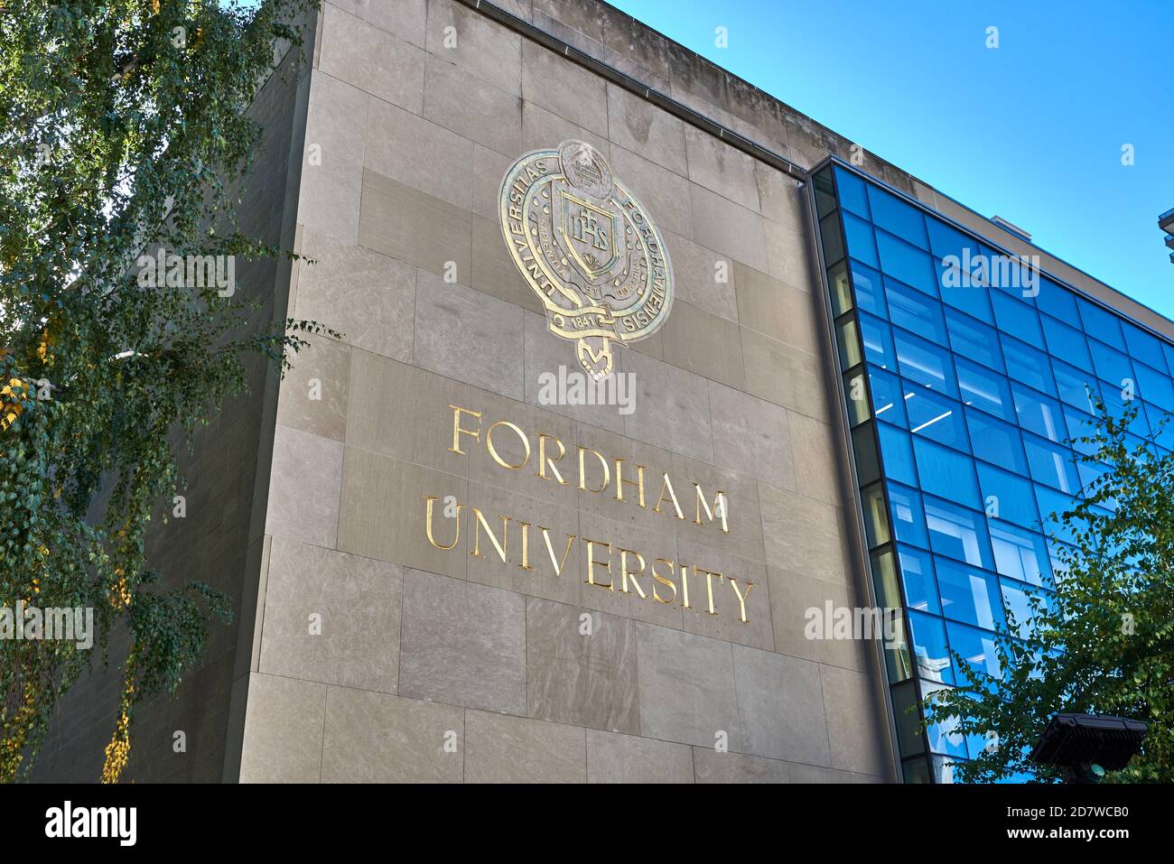 The seal of Fordham University in low relief on the side of a building ...