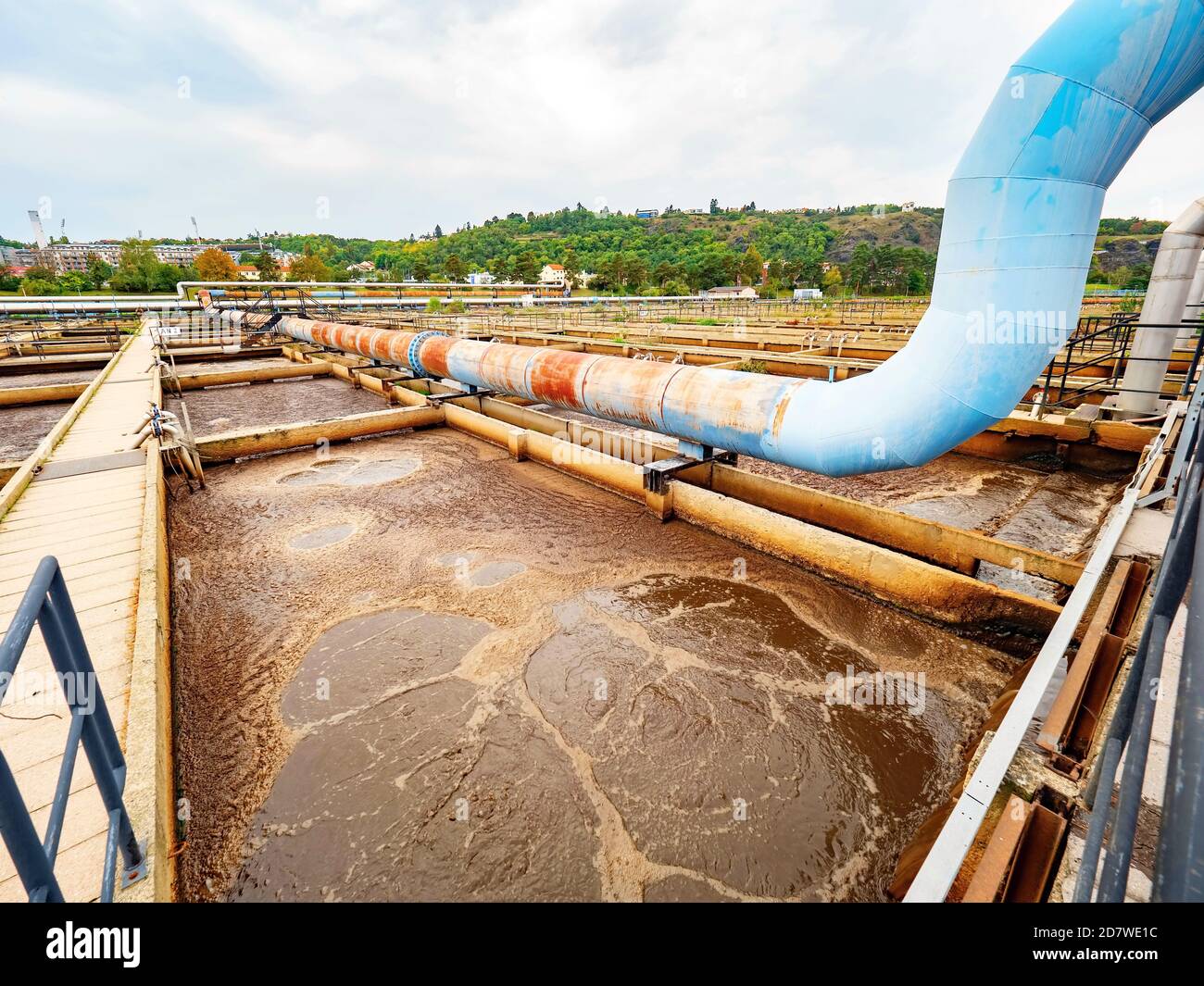 Pipe and walk bridge above waste water pool. Sedimentation tank in a ...