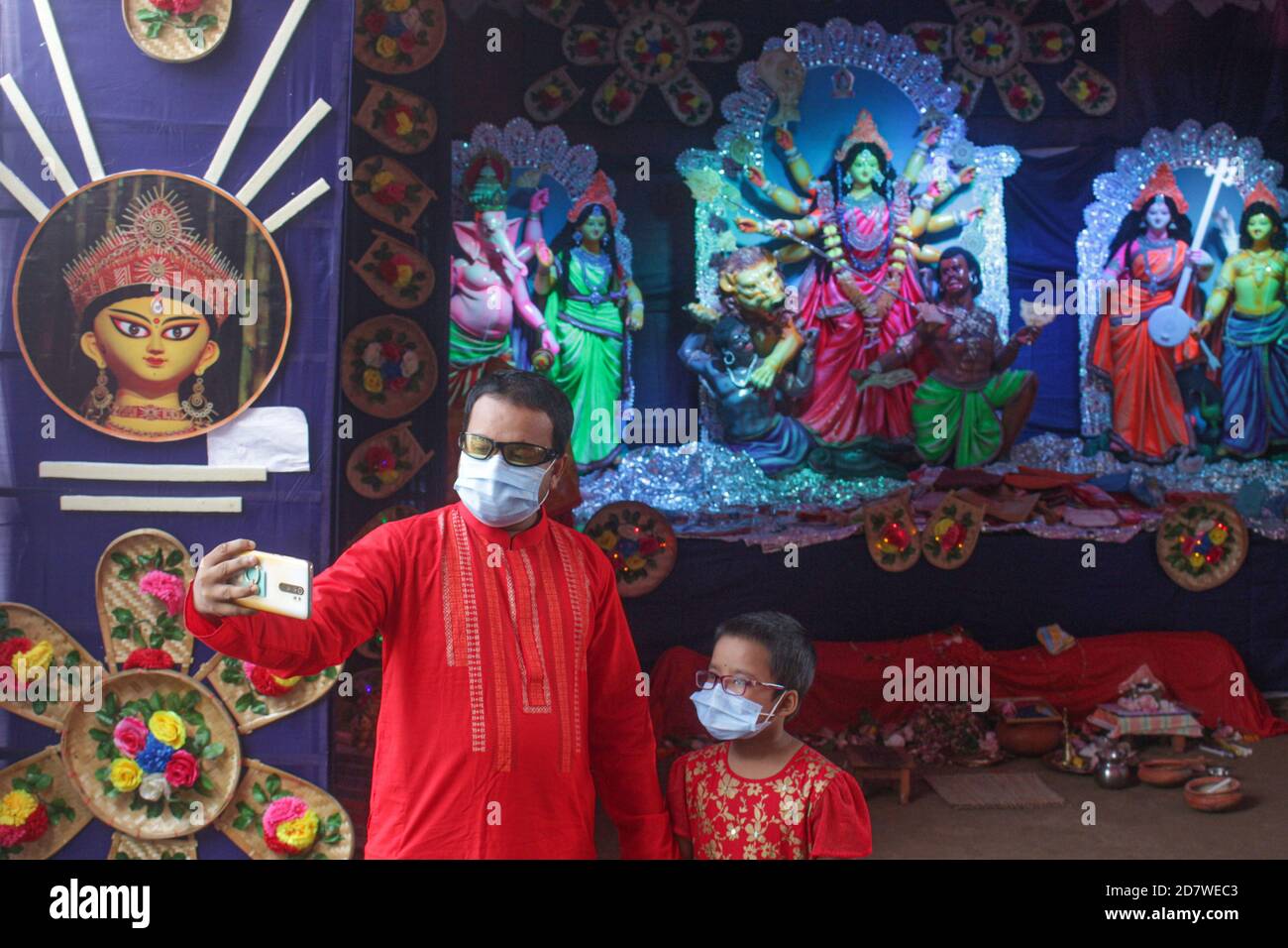 A father and daughter wearing mask and taking selfies at the worship ...