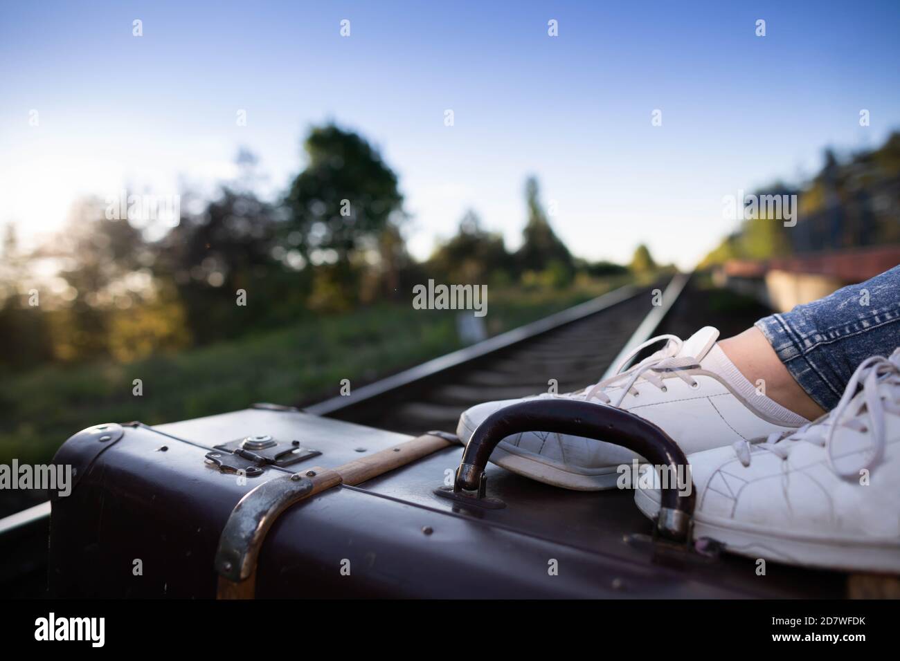 Travel suitcase. Sports shoes. Railroad tracks. In the glow of the ...