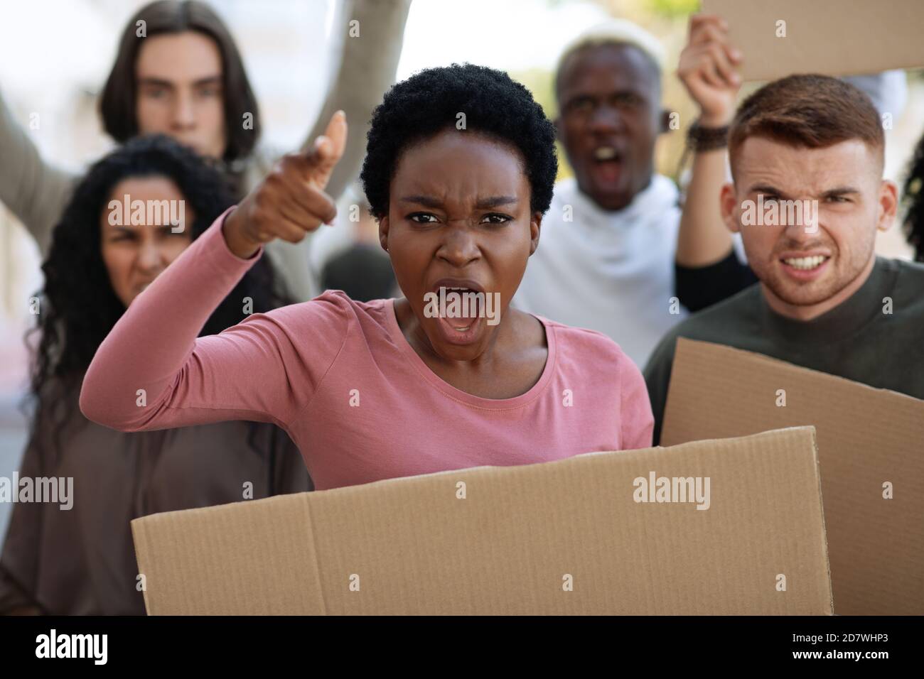 Angry international group of demonstrators protesting on the street ...