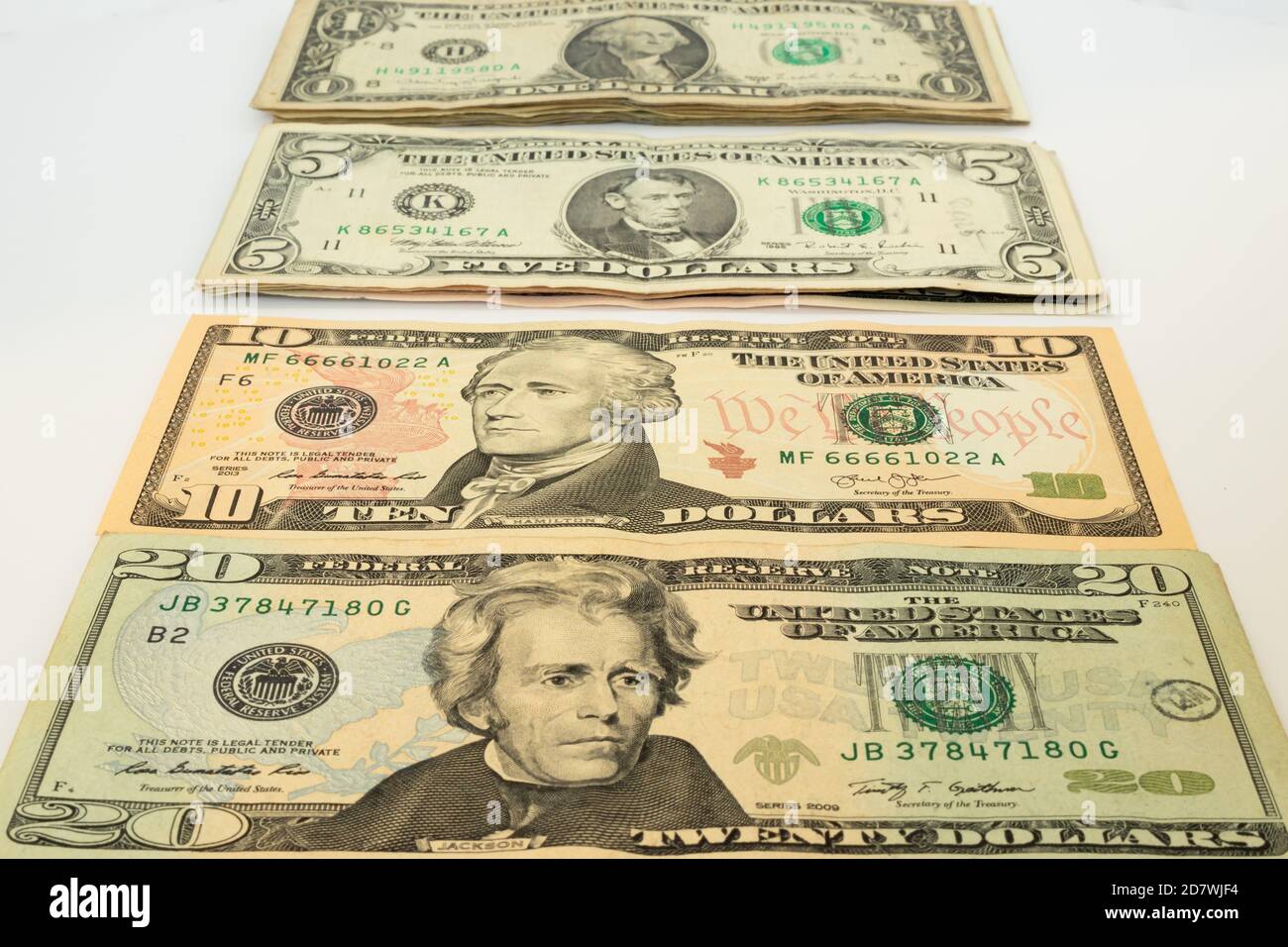 different values of US dollars arranged on a white surface Stock Photo ...