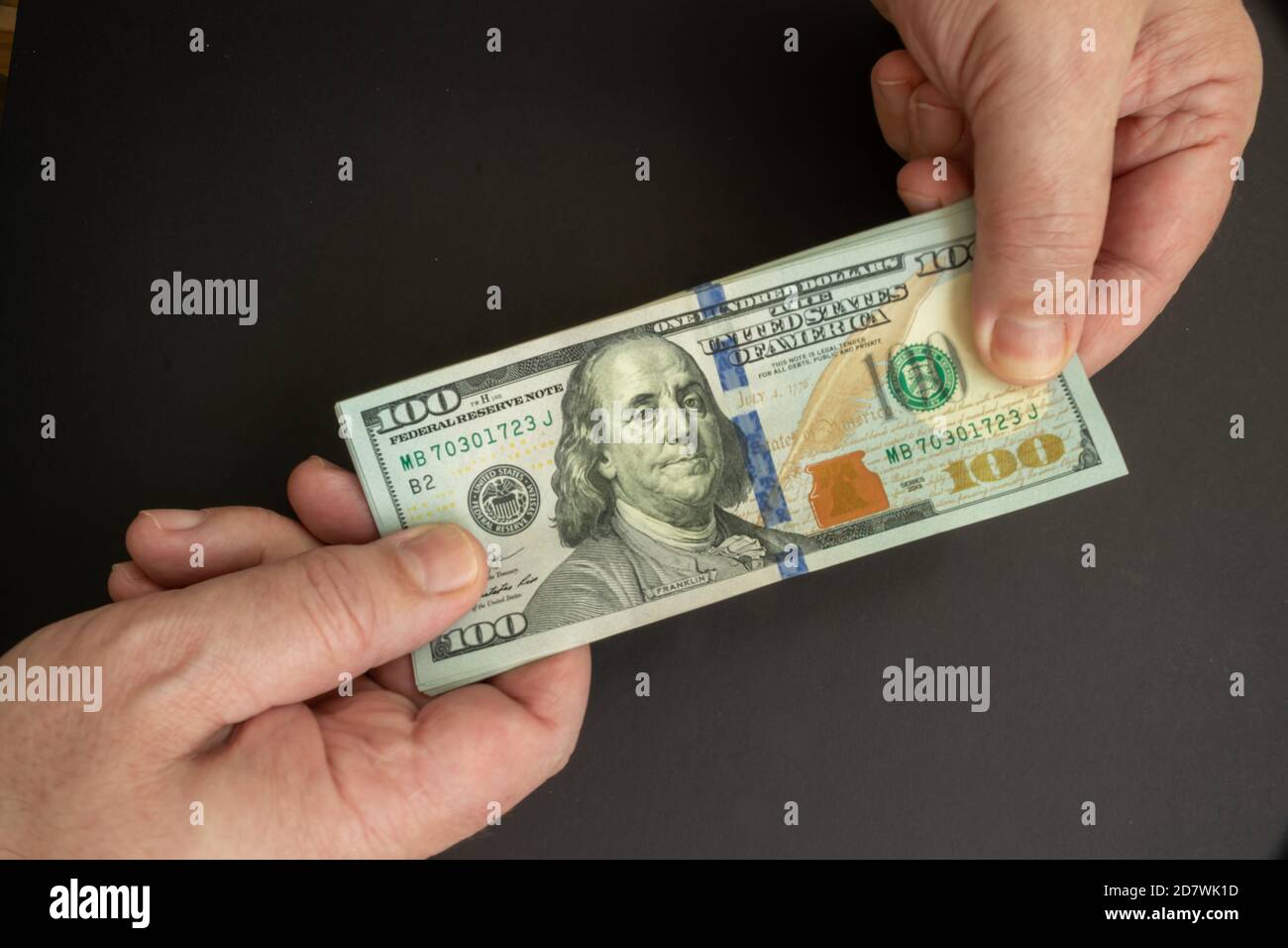 Hands counting American 100 dollar bills on a black background Stock ...