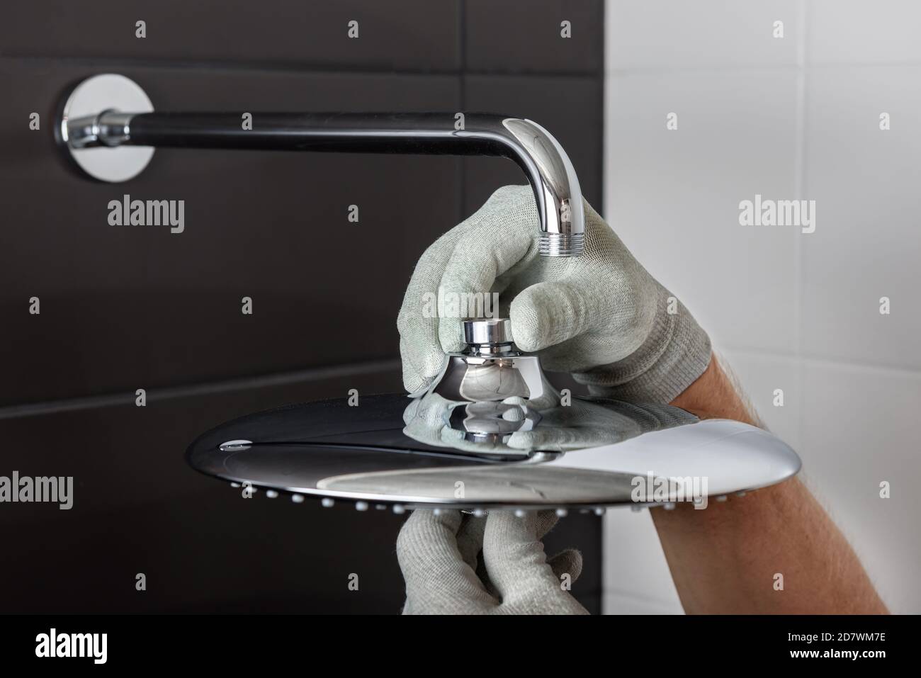 The worker's hands install the head of the built-in shower faucet Stock ...