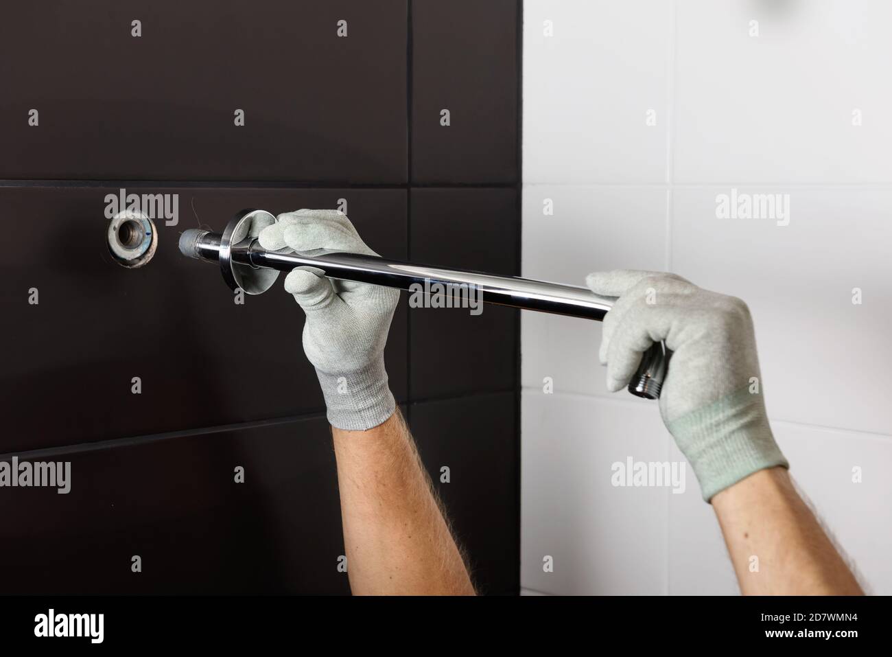 The worker's hands install the tube of the built-in shower faucet Stock ...