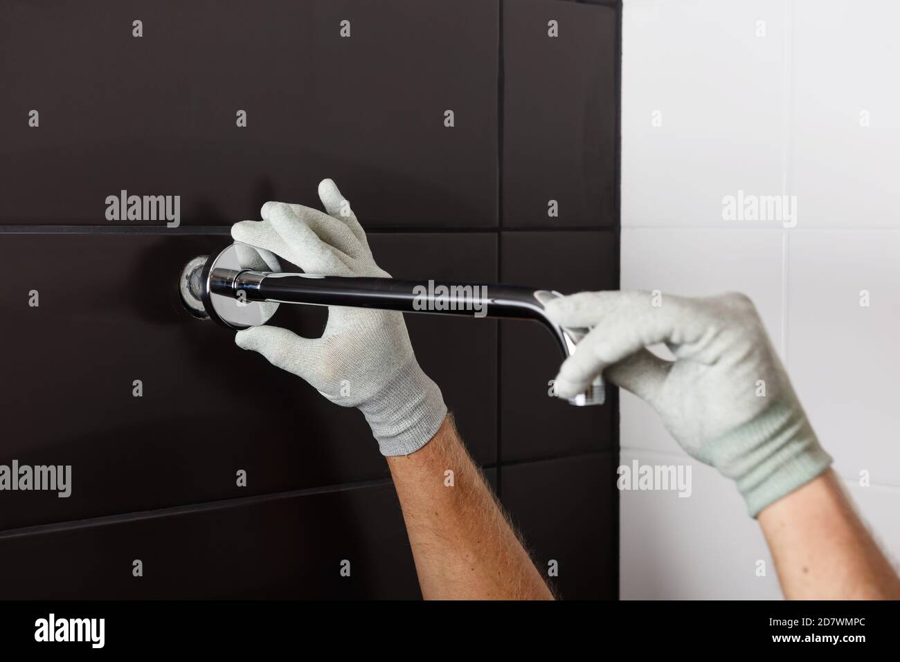 The worker's hands install the tube of the built-in shower faucet Stock ...