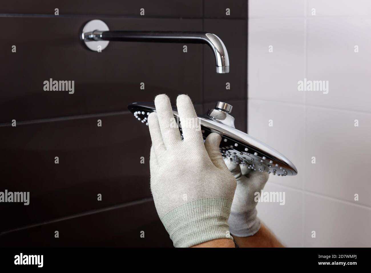 The worker's hands install the head of the built-in shower faucet Stock ...