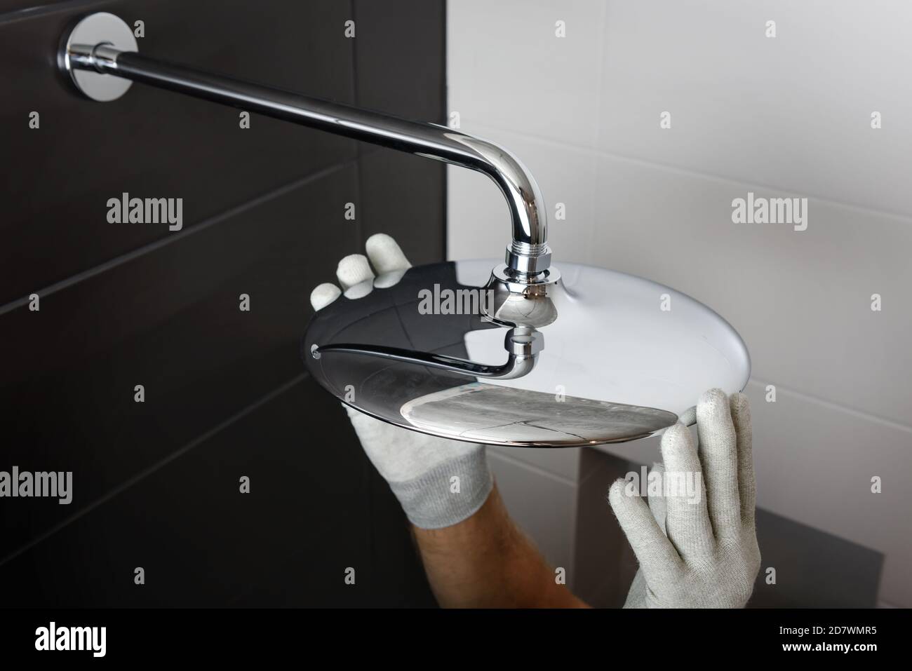The worker's hands install the head of the built-in shower faucet Stock ...