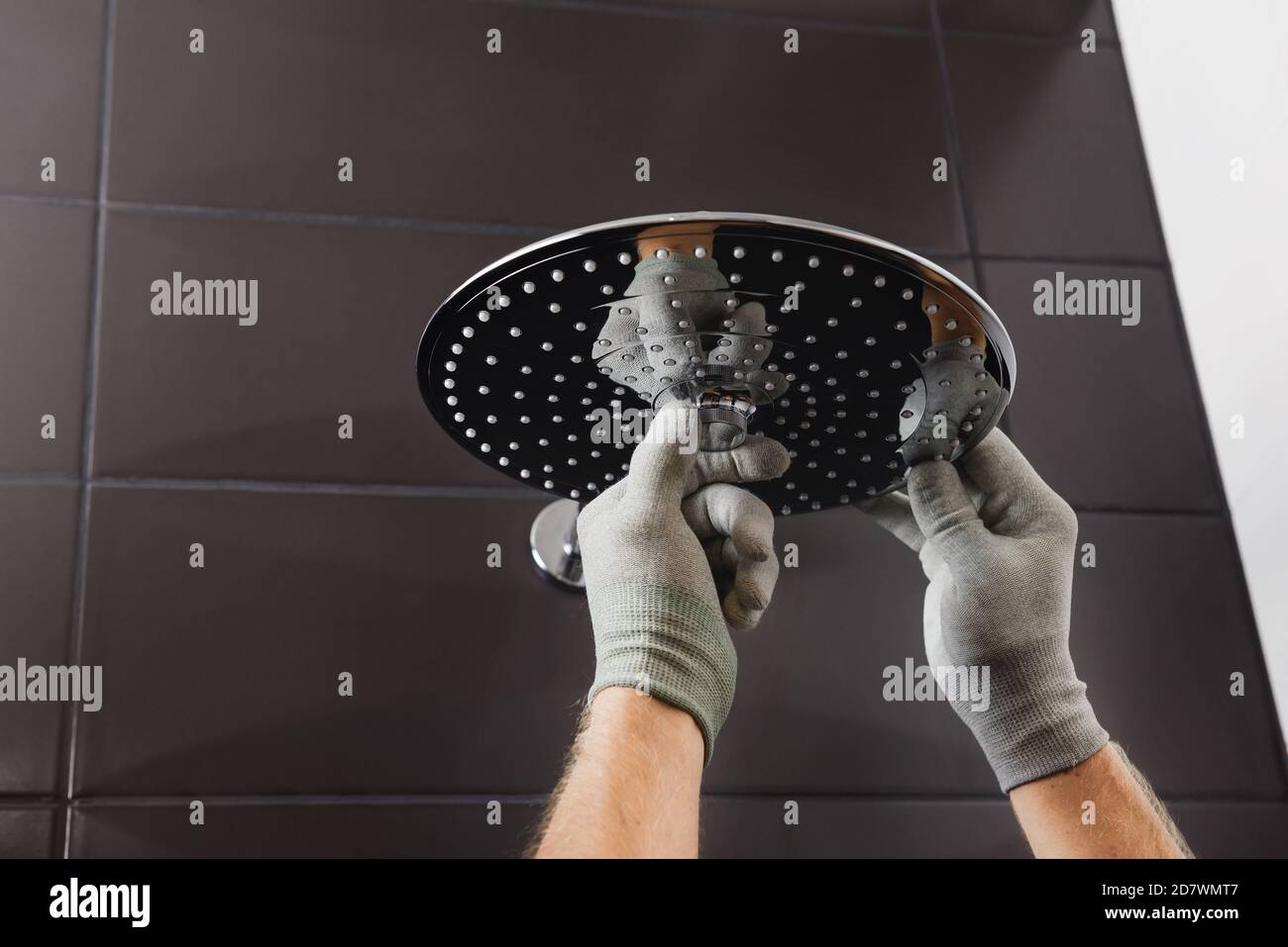 The worker's hands install the head of the built-in shower faucet Stock ...