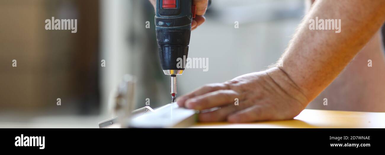 Hand with screwdriver fasten details with close-up Stock Photo - Alamy
