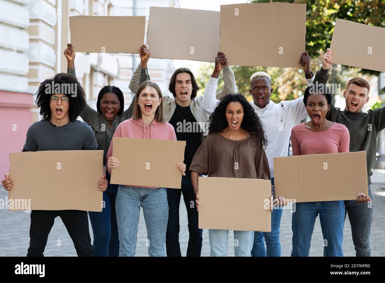 Furious mutiracial group of demonstrators protesting on the street ...
