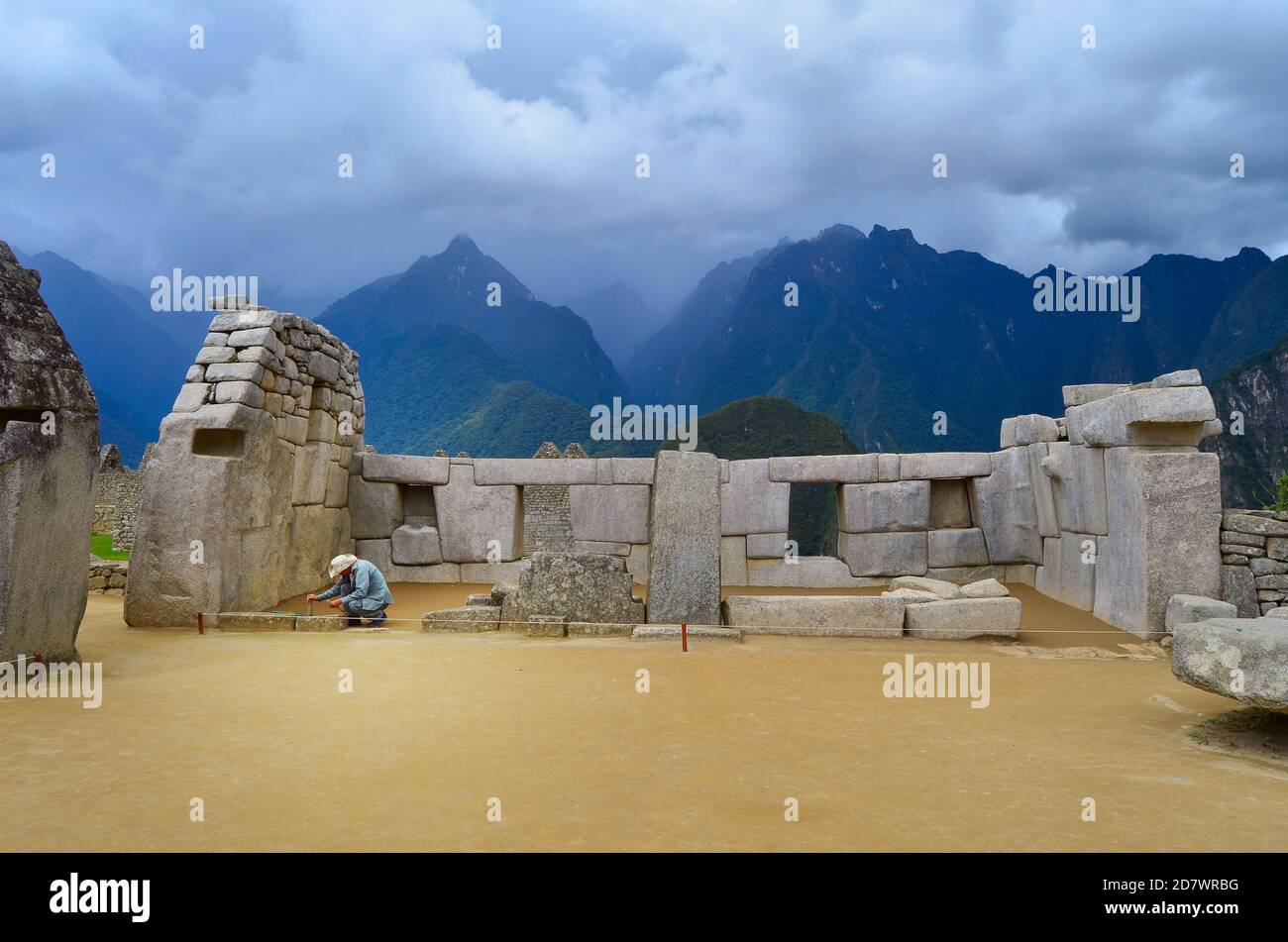 Machu Picchu interior, a man working on reconstruction Stock Photo - Alamy