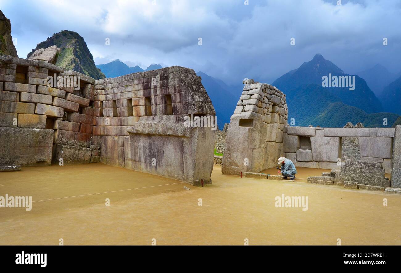 Machu Picchu interior, a man working on reconstruction Stock Photo - Alamy