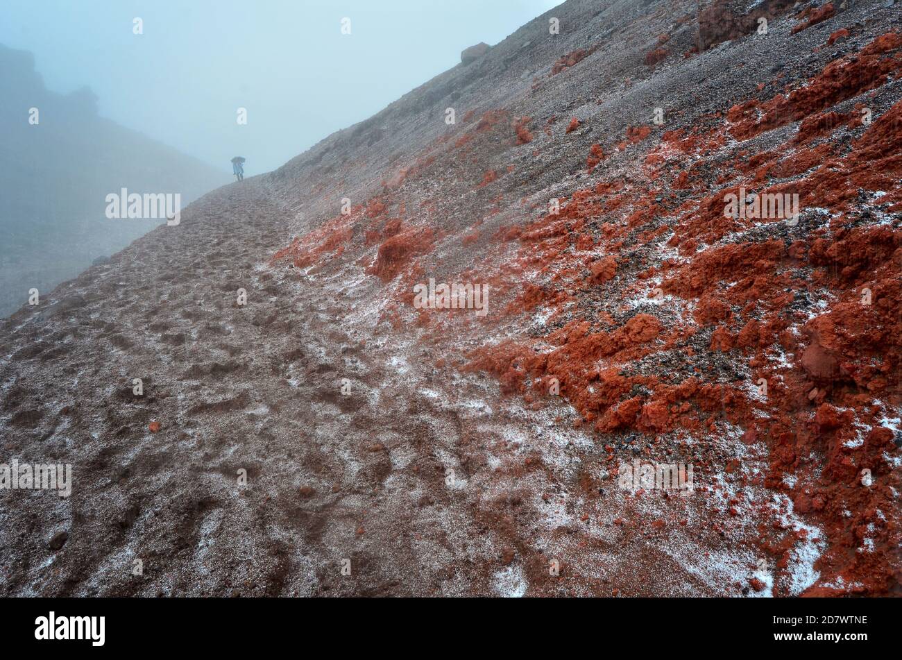 Slopes of Cotopaxi Volcano and red volcanic soil on a foggy day ...