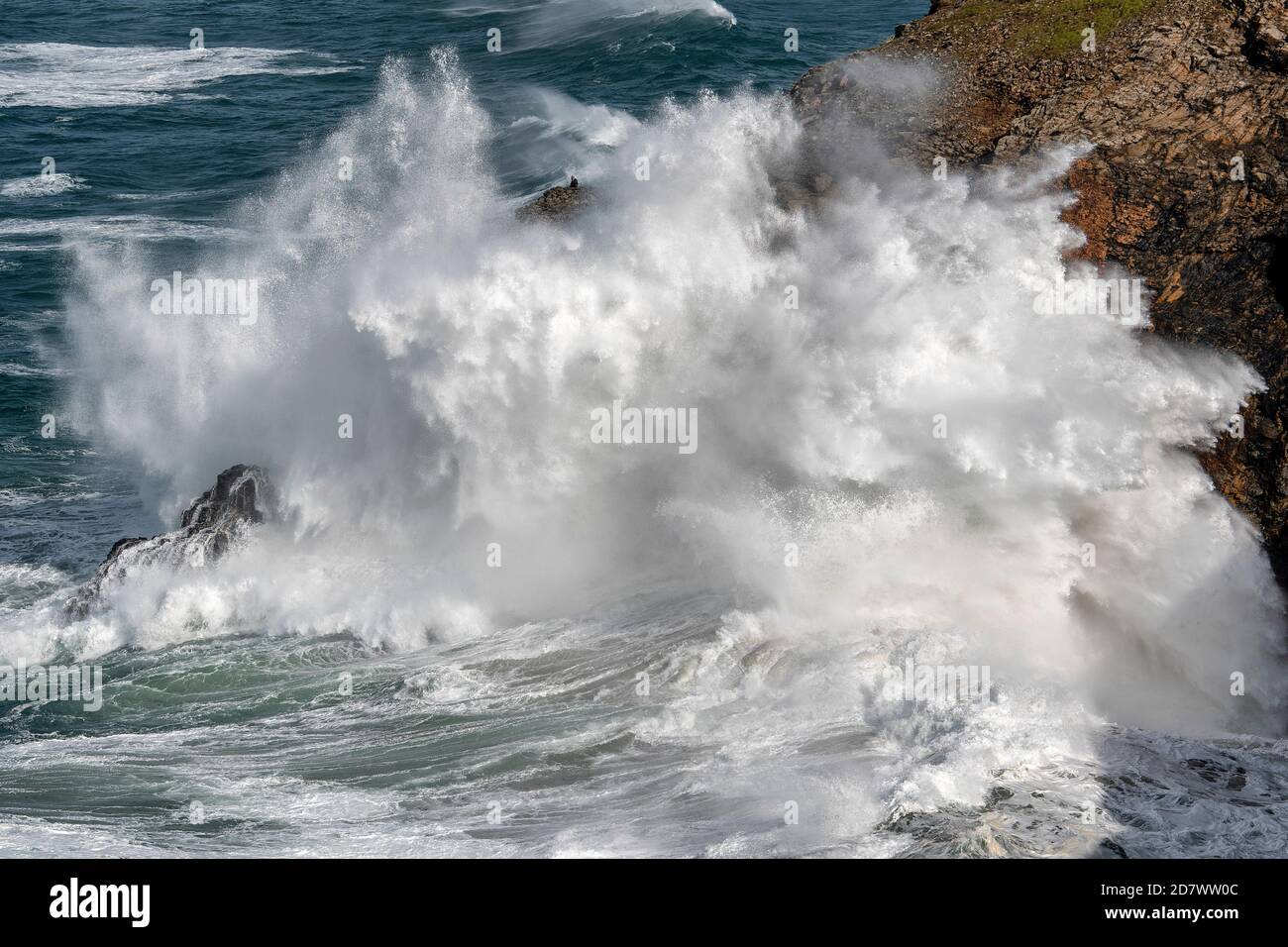 Two fisherman brave huge waves on cliffs near Perranporth in Cornwall ...