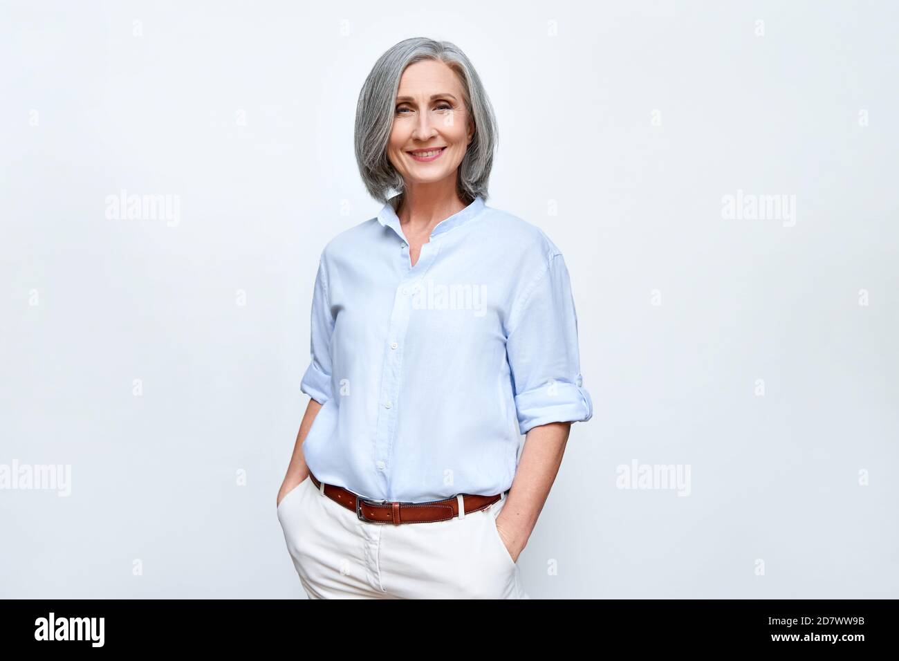 Smiling middle aged business woman standing isolated on white ...