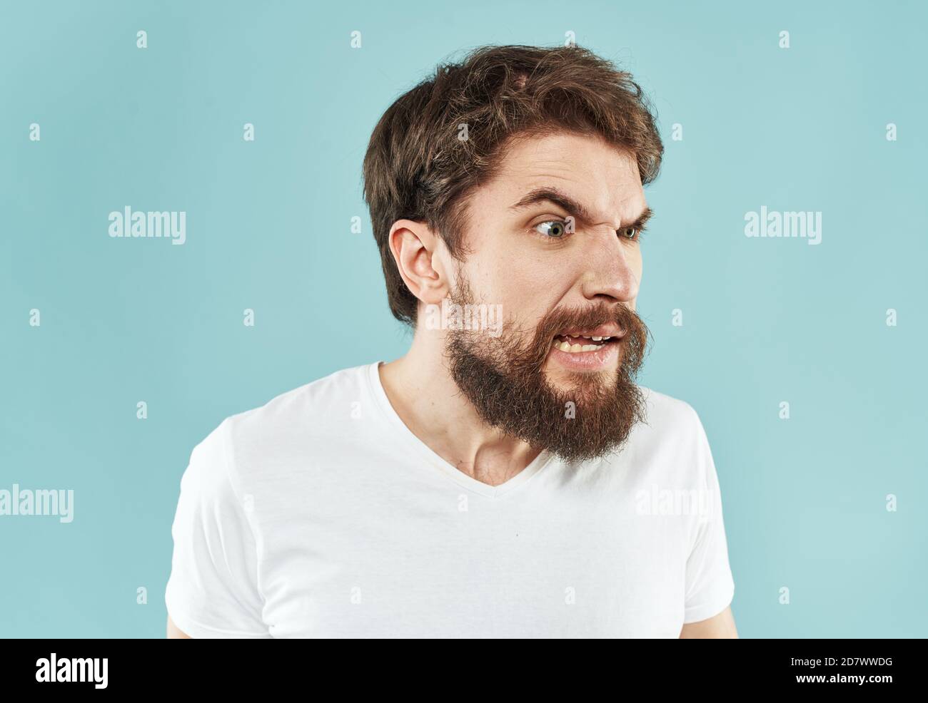 Aggressive man with a beard on a blue background cropped view Stock ...