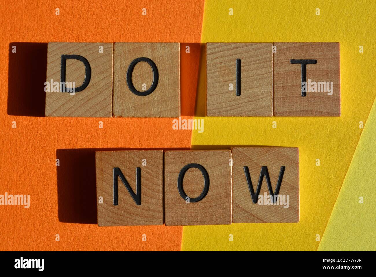 Do It Now, words in wooden alphabet letters isolated on yellow and ...