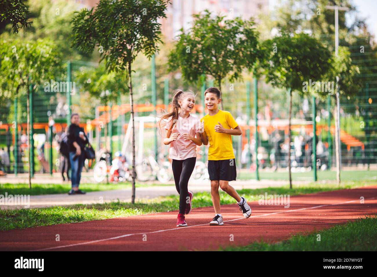 Sports and fitness in adolescence. Caucasian twins boy and girl run on ...