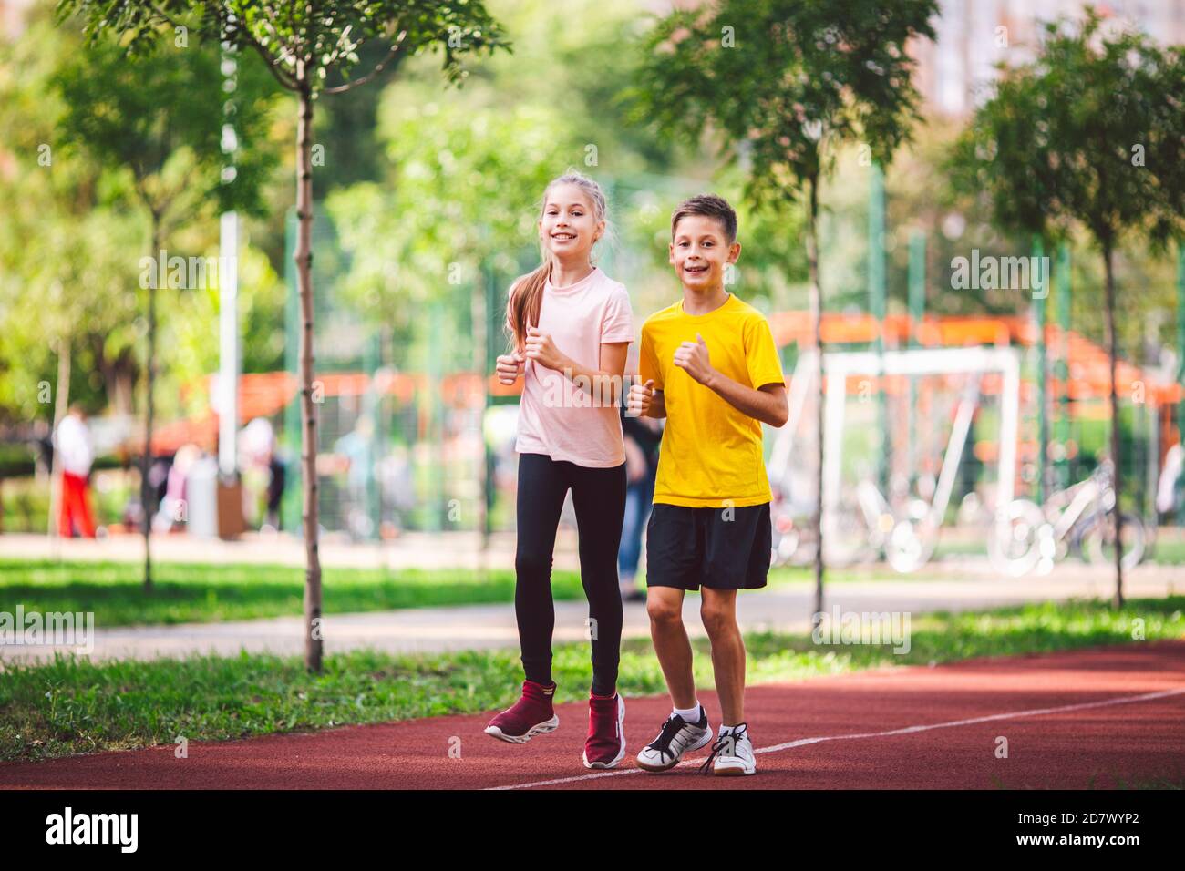 Child fitness, twins kids running on stadium track in city park ...