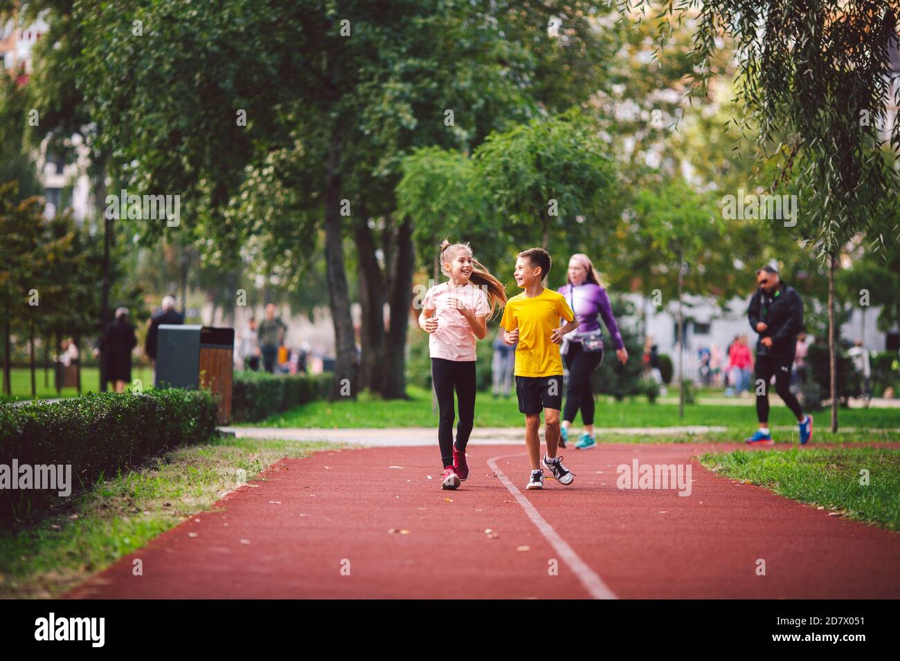 Couple of kids boy and girl doing cardio workout, jogging in park on ...