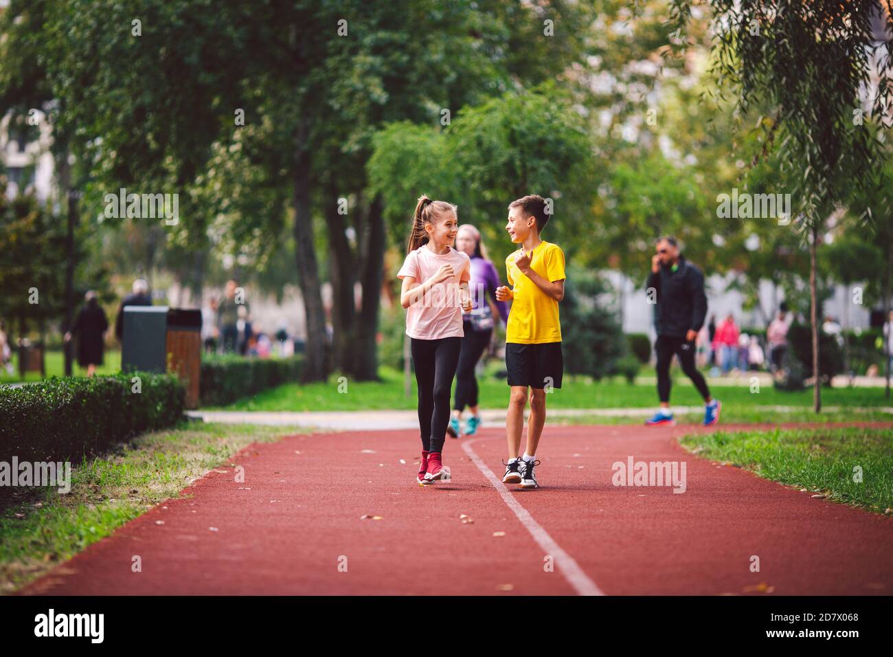 Child fitness, twins kids running on stadium track in city park ...