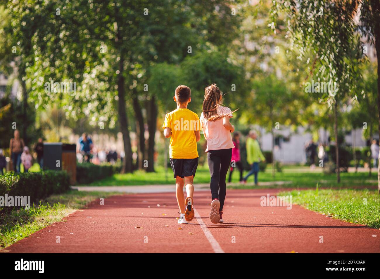 Sports and fitness in adolescence. Caucasian twins boy and girl run on ...