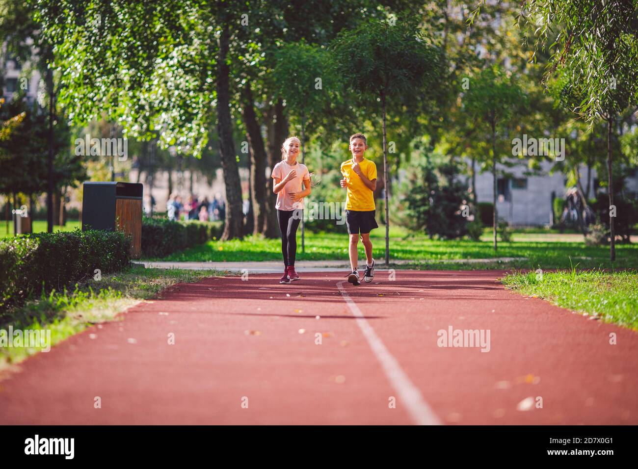 Couple of kids boy and girl doing cardio workout, jogging in park on ...