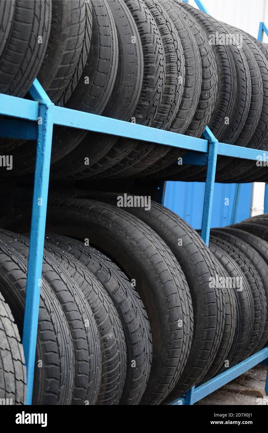 Rack with variety of car tires in automobile store. Many black tires ...