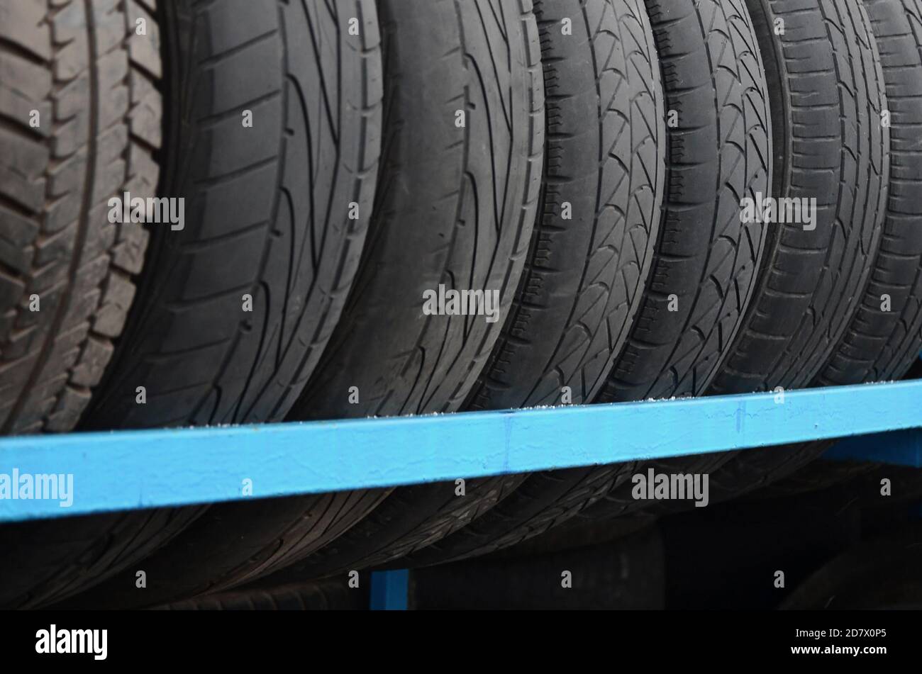 Rack with variety of car tires in automobile store. Many black tires ...