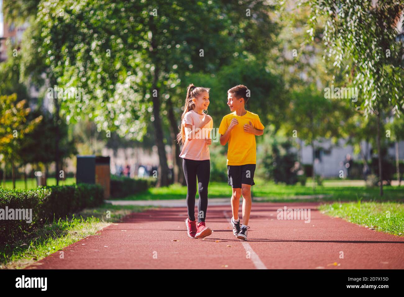 Sports and fitness in adolescence. Caucasian twins boy and girl run on ...