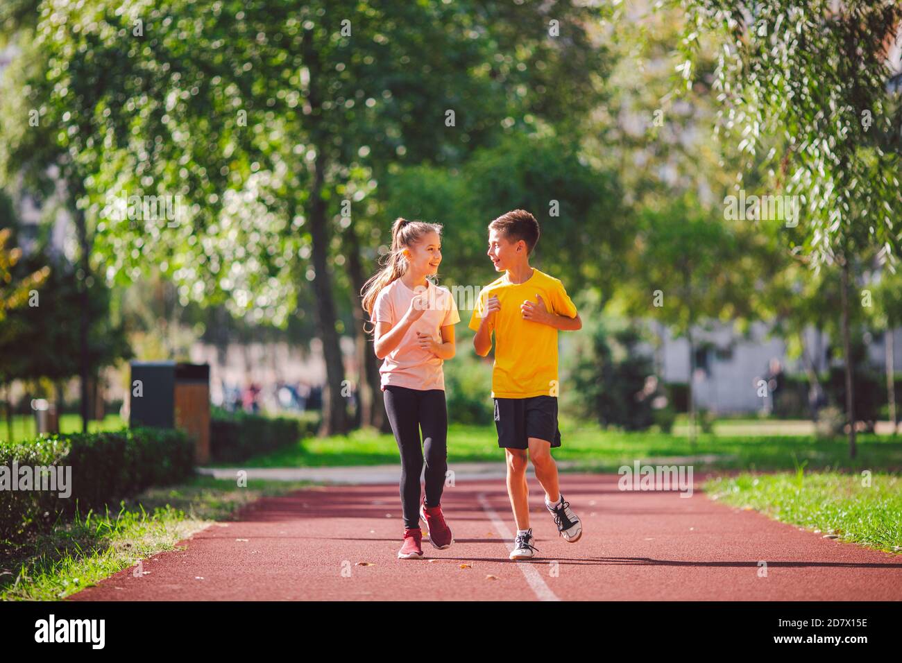 Child fitness, twins kids running on stadium track in city park ...