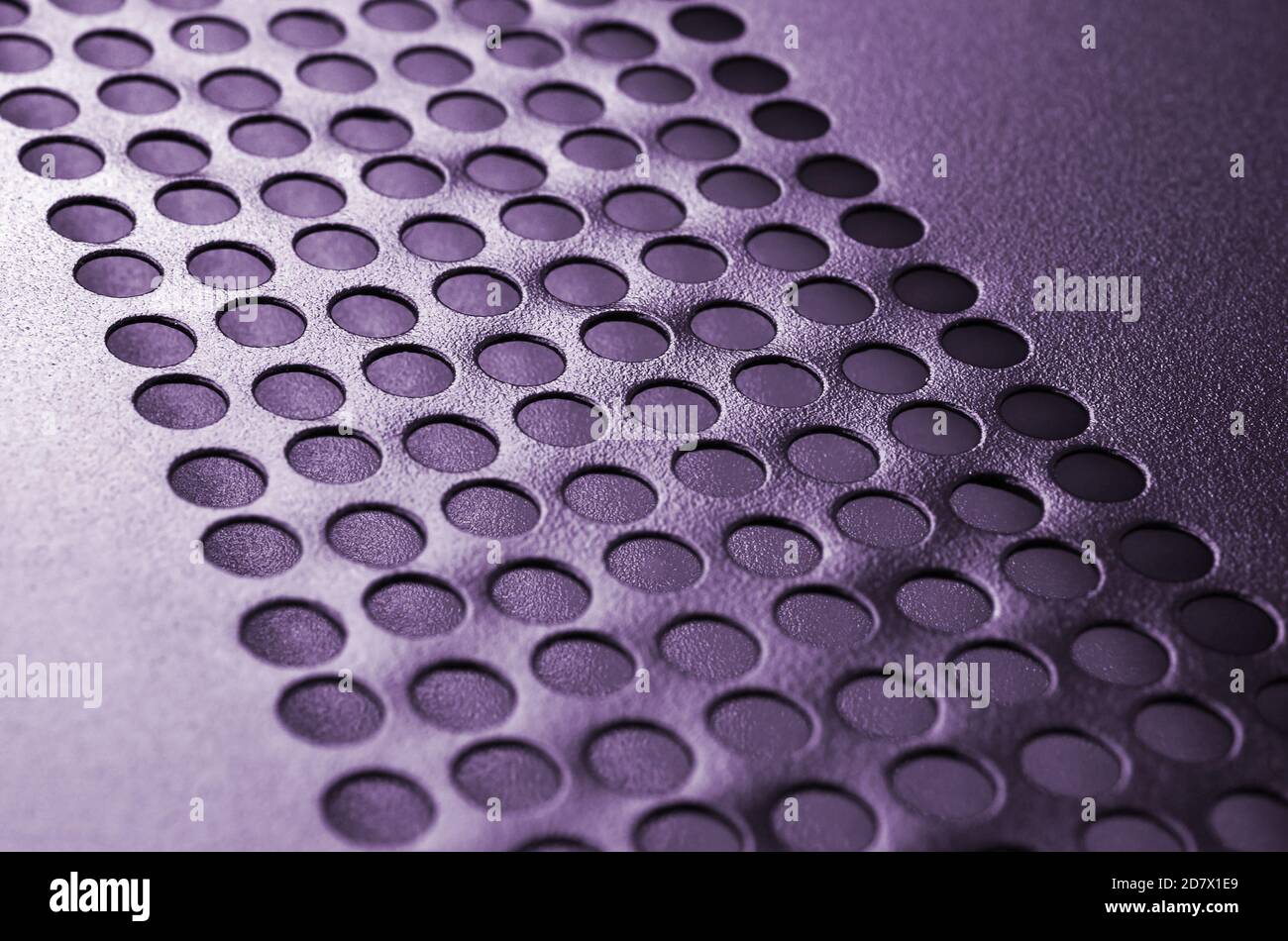 Black metal computer case panel mesh with holes on purple background ...