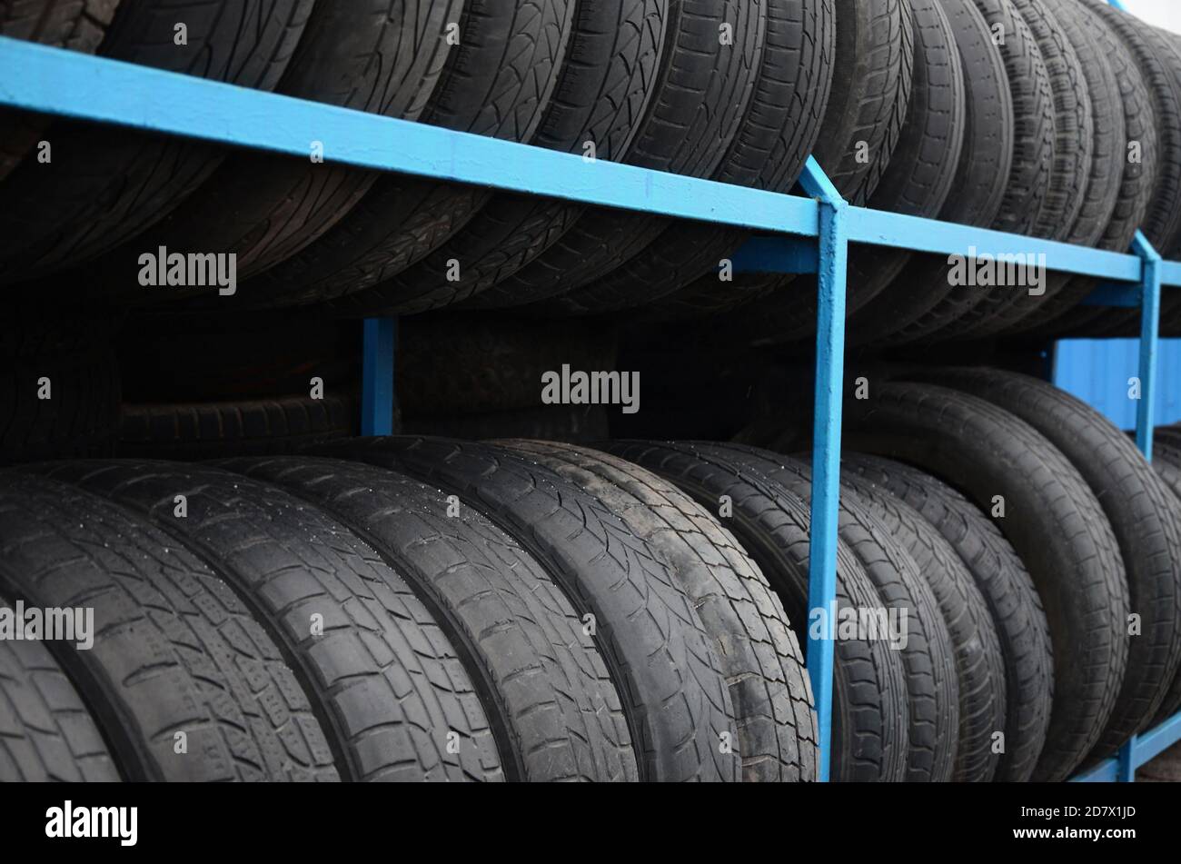 Rack with variety of car tires in automobile store. Many black tires ...